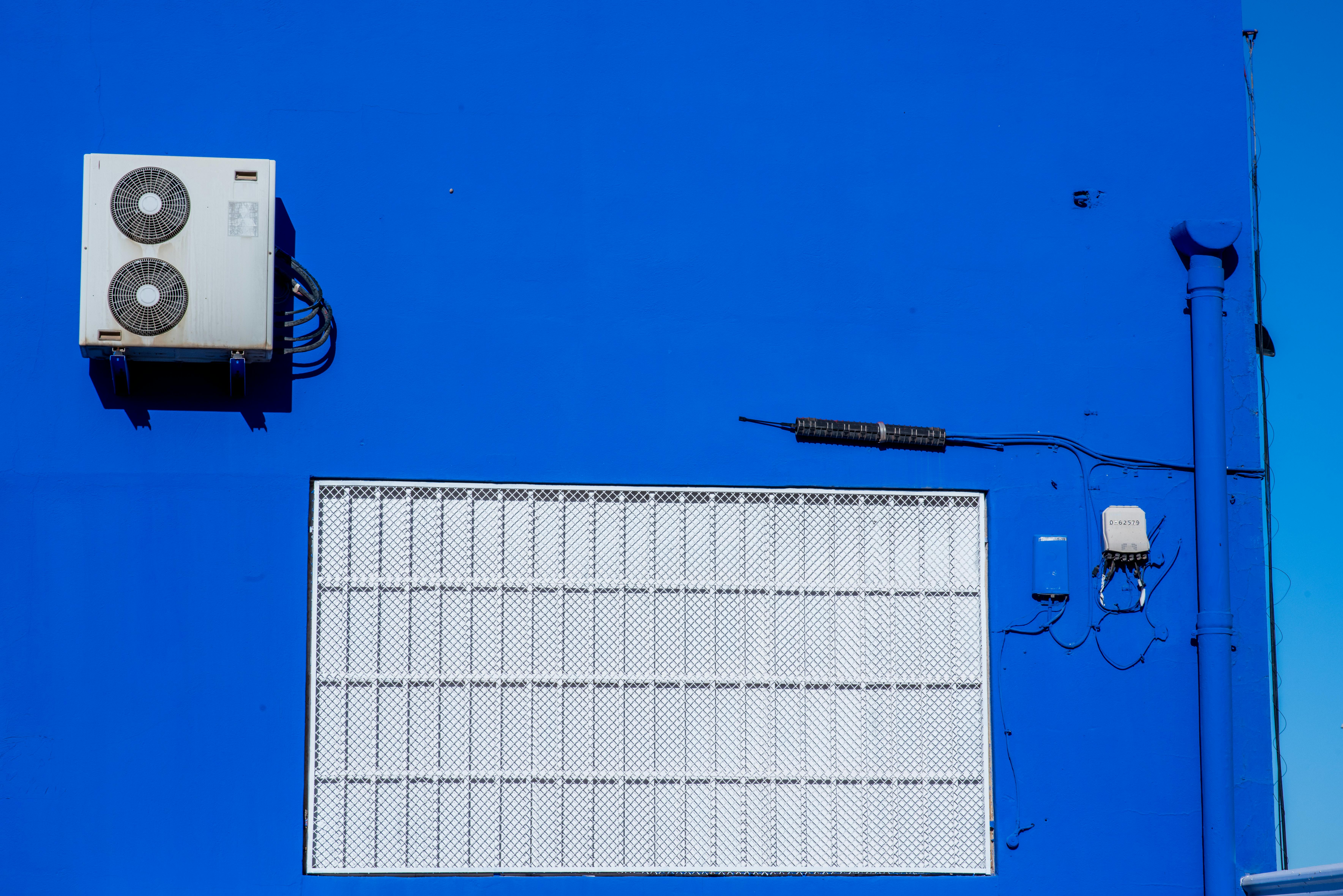 Air Conditioner on Vibrant Blue Wall Exterior · Free Stock Photo