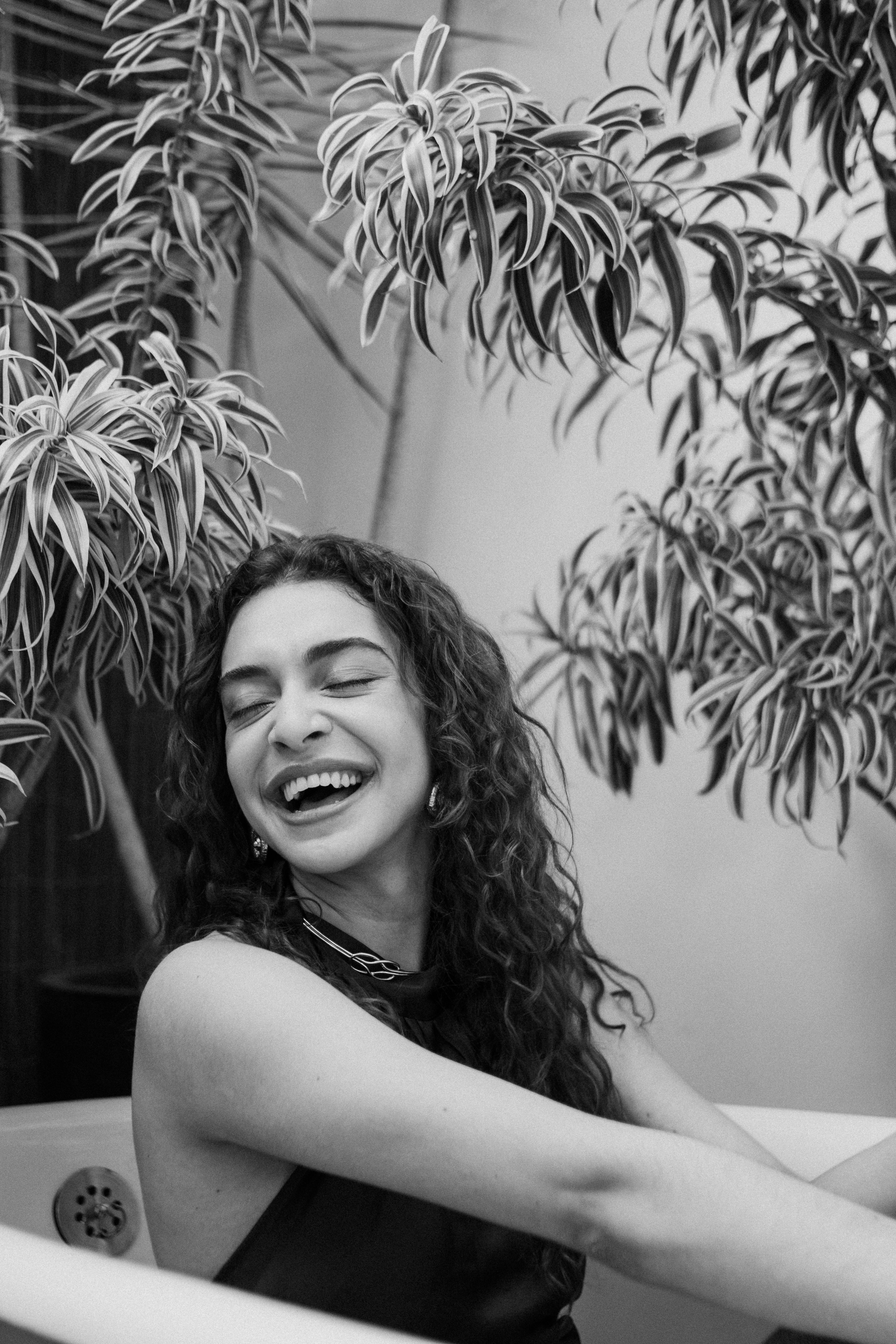 Joyful Woman Laughing Among Indoor Plants · Free Stock Photo