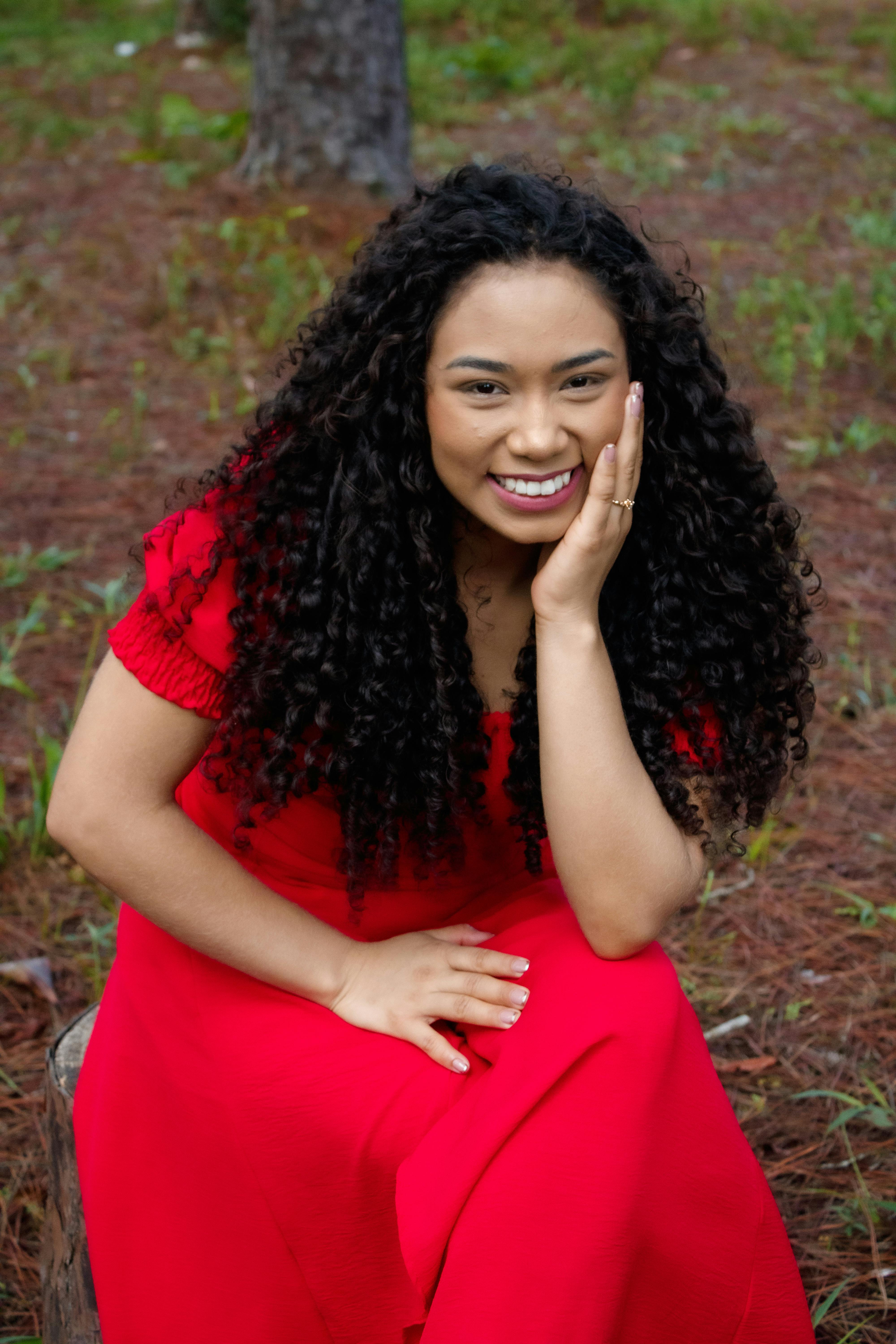 Smiling Woman in Red Dress Outdoors · Free Stock Photo