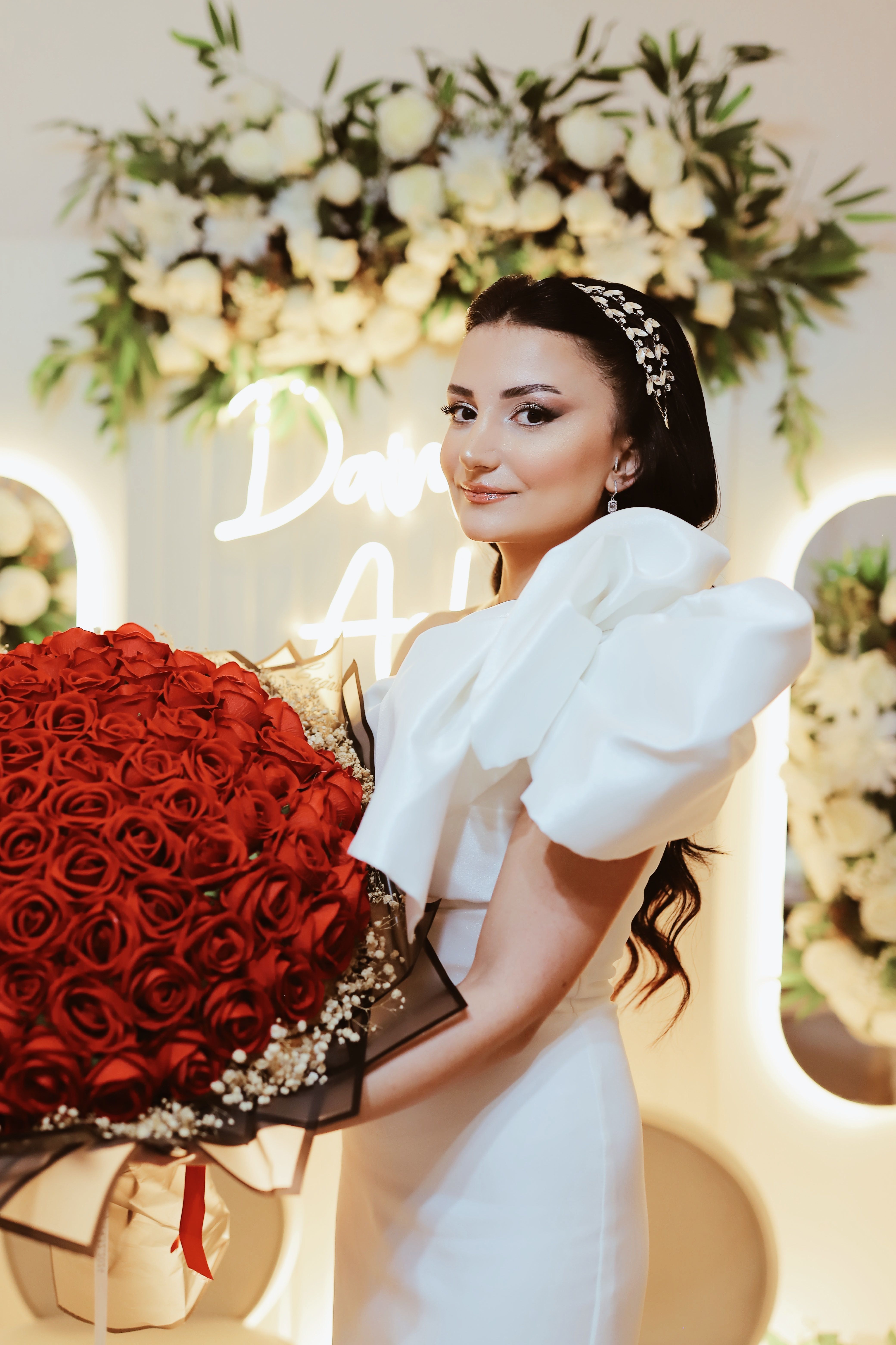 Elegant Bride Holding a Bouquet of Red Roses · Free Stock Photo