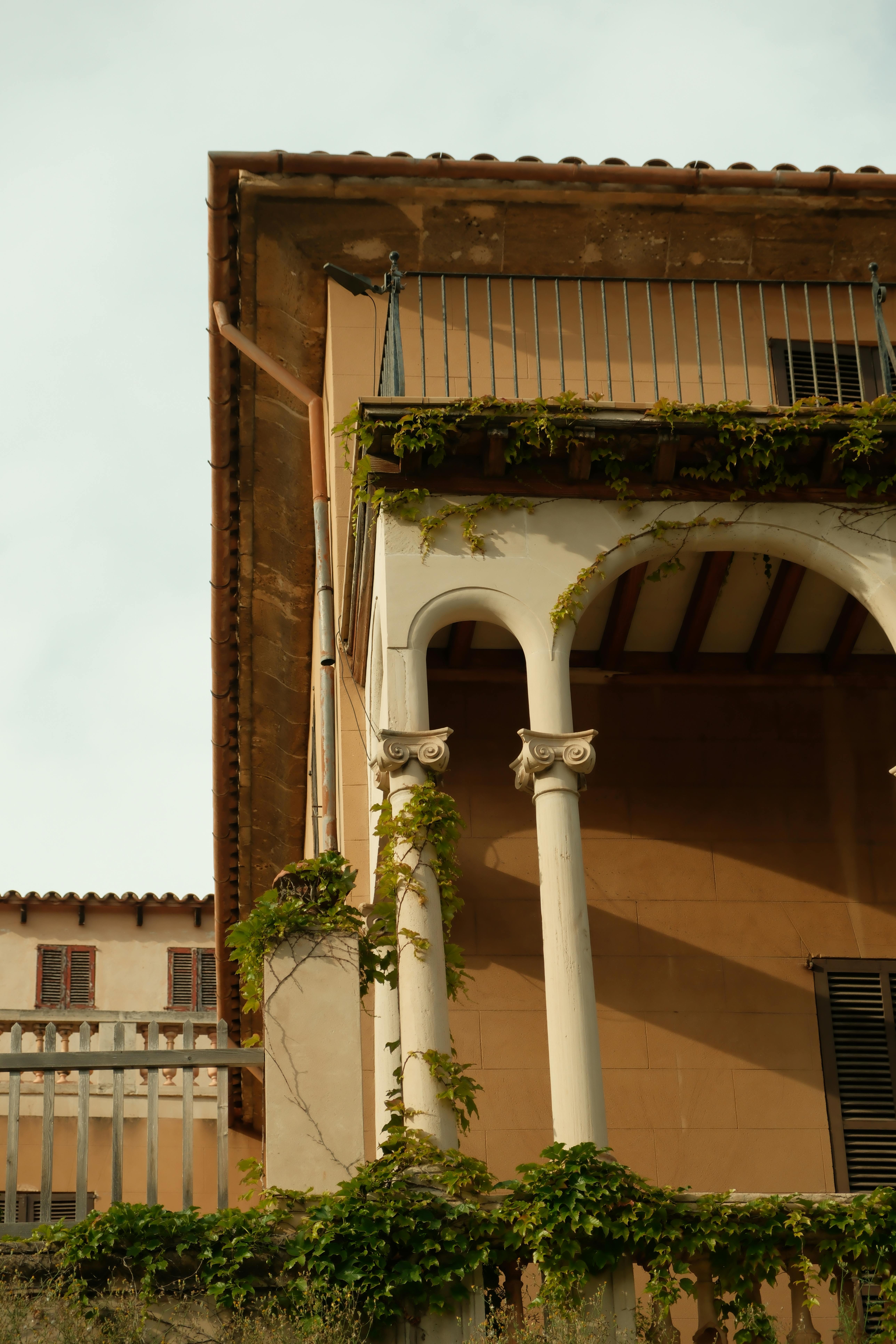 Historic Spanish Architecture with Ivy-covered Columns · Free Stock Photo