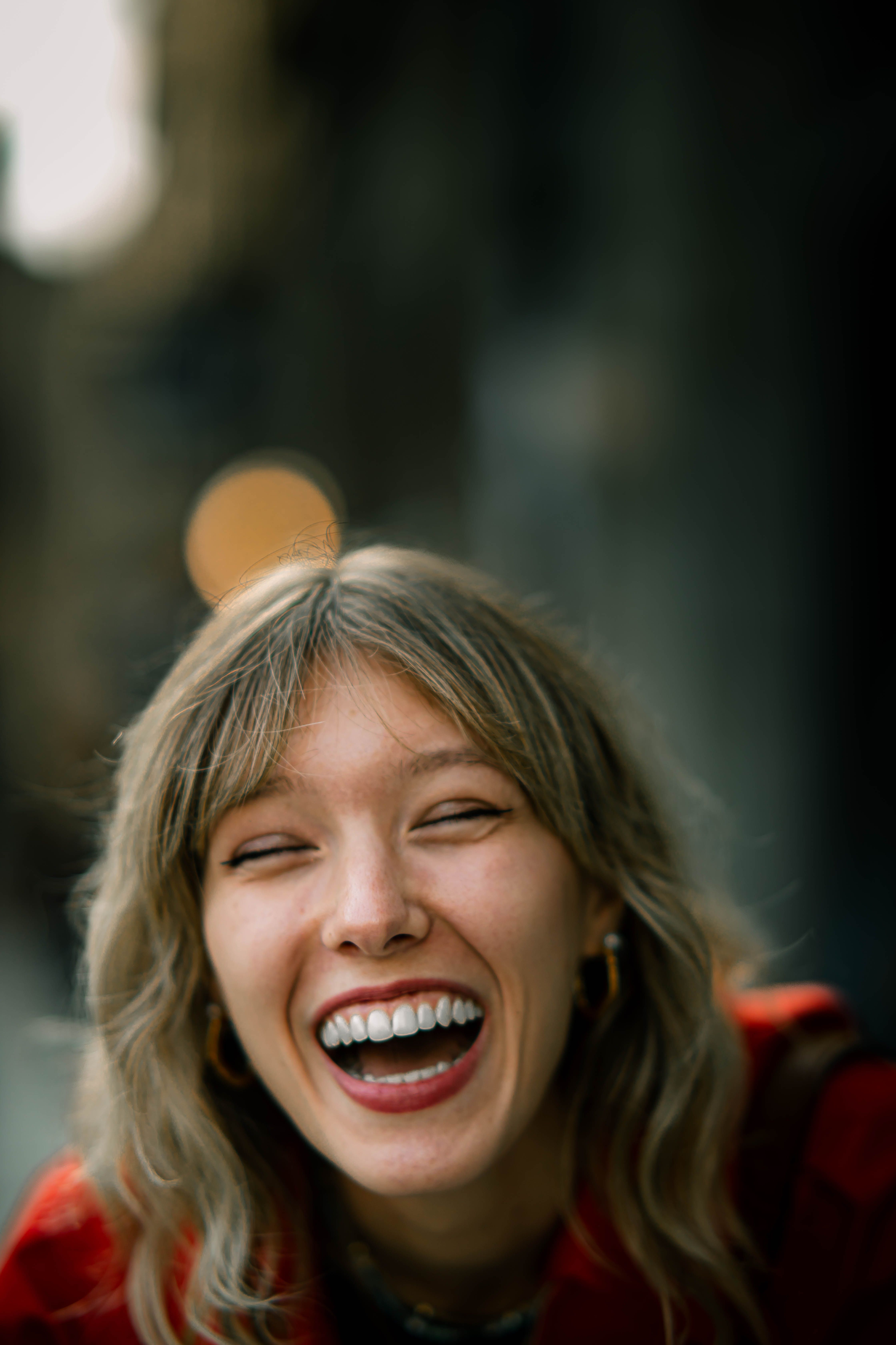 Joyful Woman Laughing Outdoors in Natural Light · Free Stock Photo