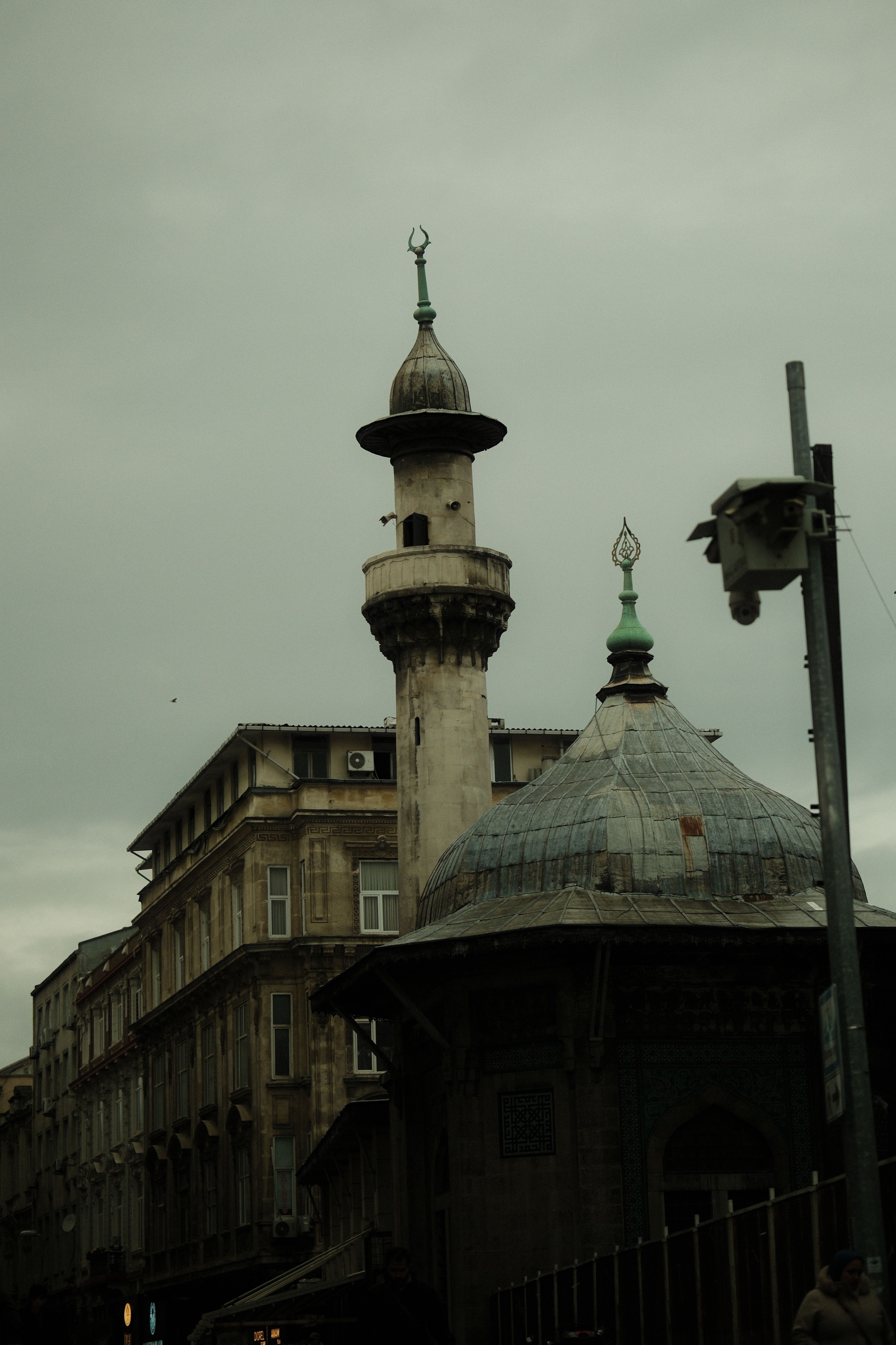 Historic Minaret and Building Under Overcast Sky · Free Stock Photo