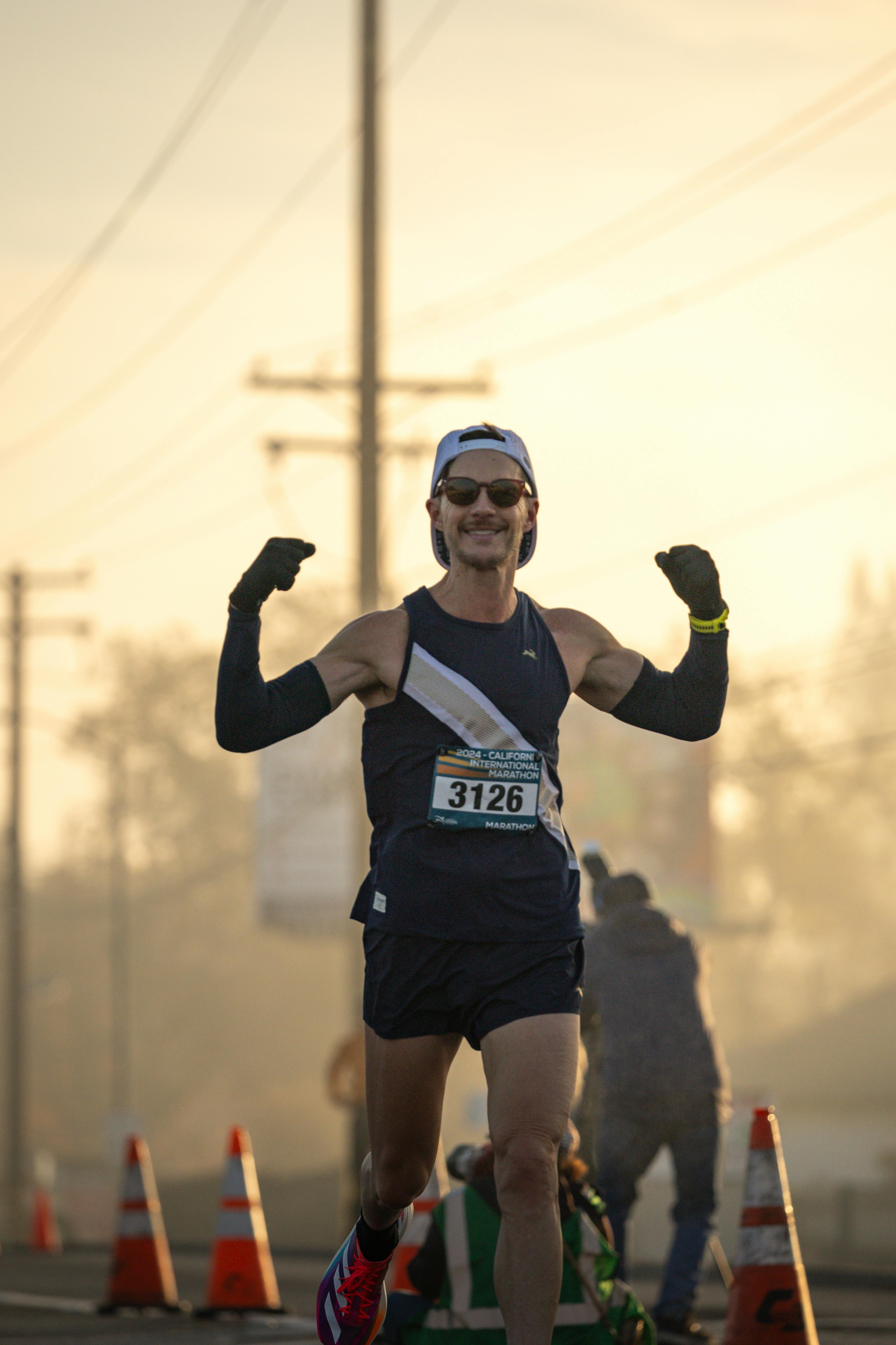Male marathon runner celebrating finish line victory · Free Stock Photo