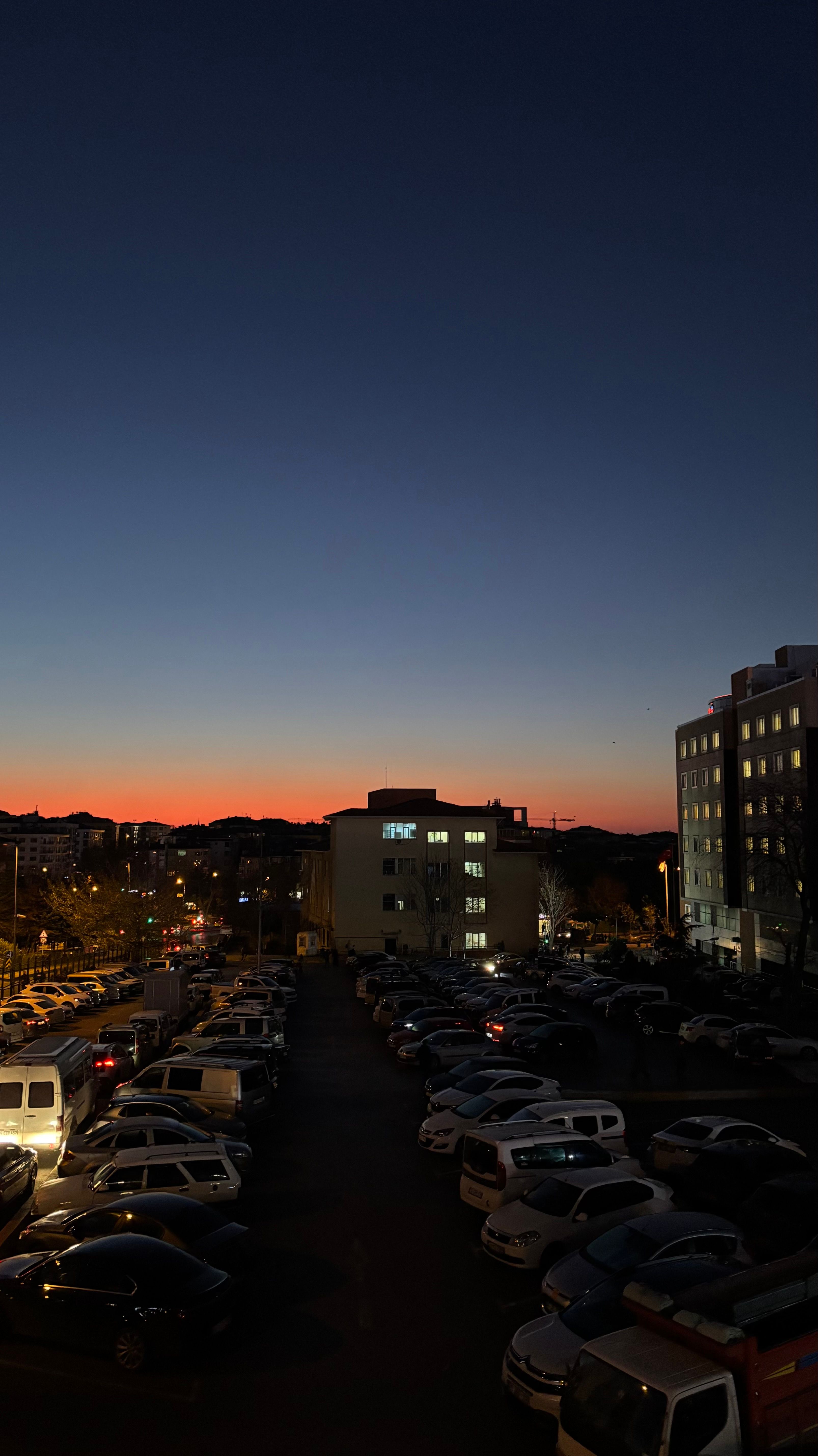 Dramatic Urban Sunset Over a Busy Parking Lot · Free Stock Photo