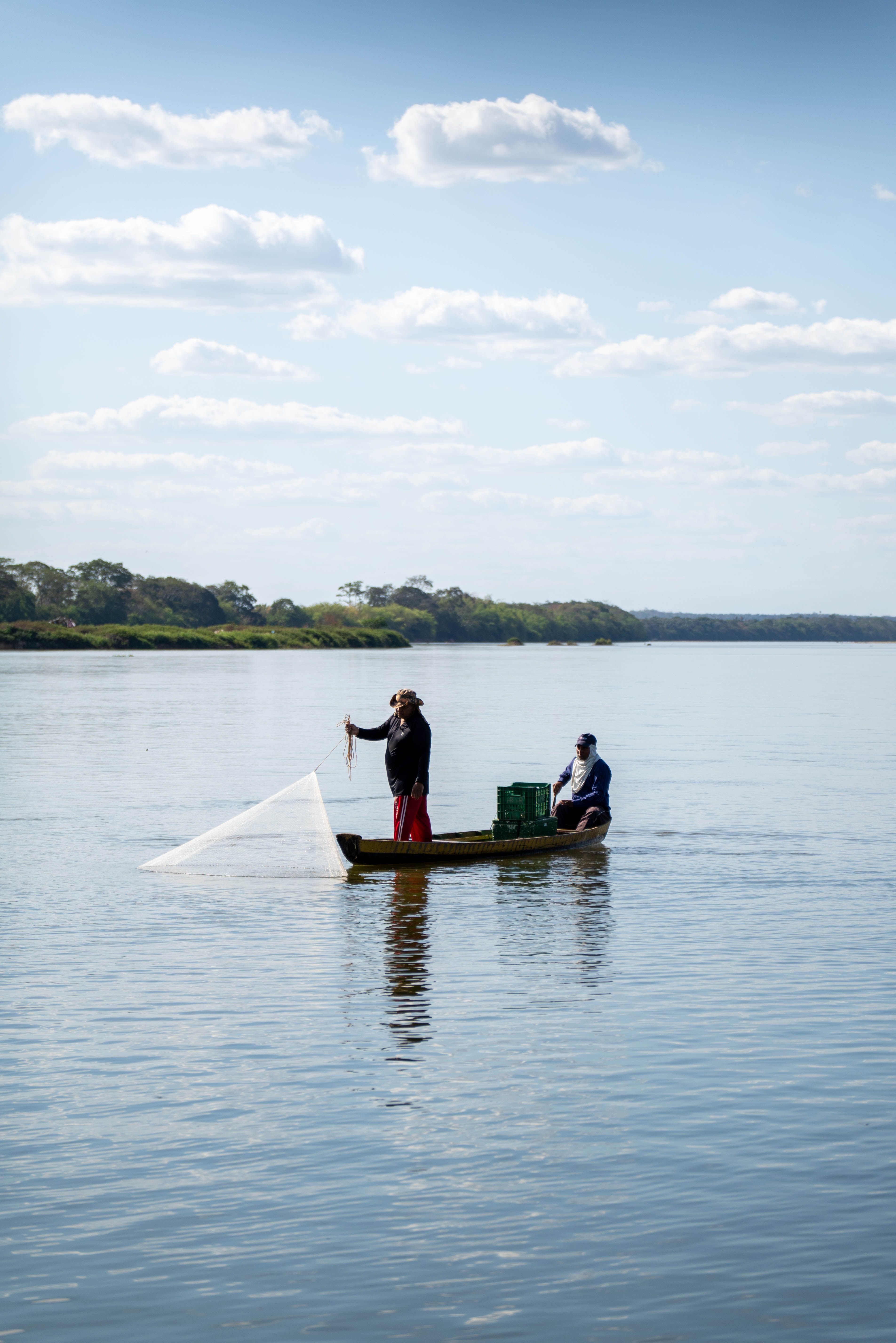 Fishermen on Tranquil Lake Casting Nets · Free Stock Photo
