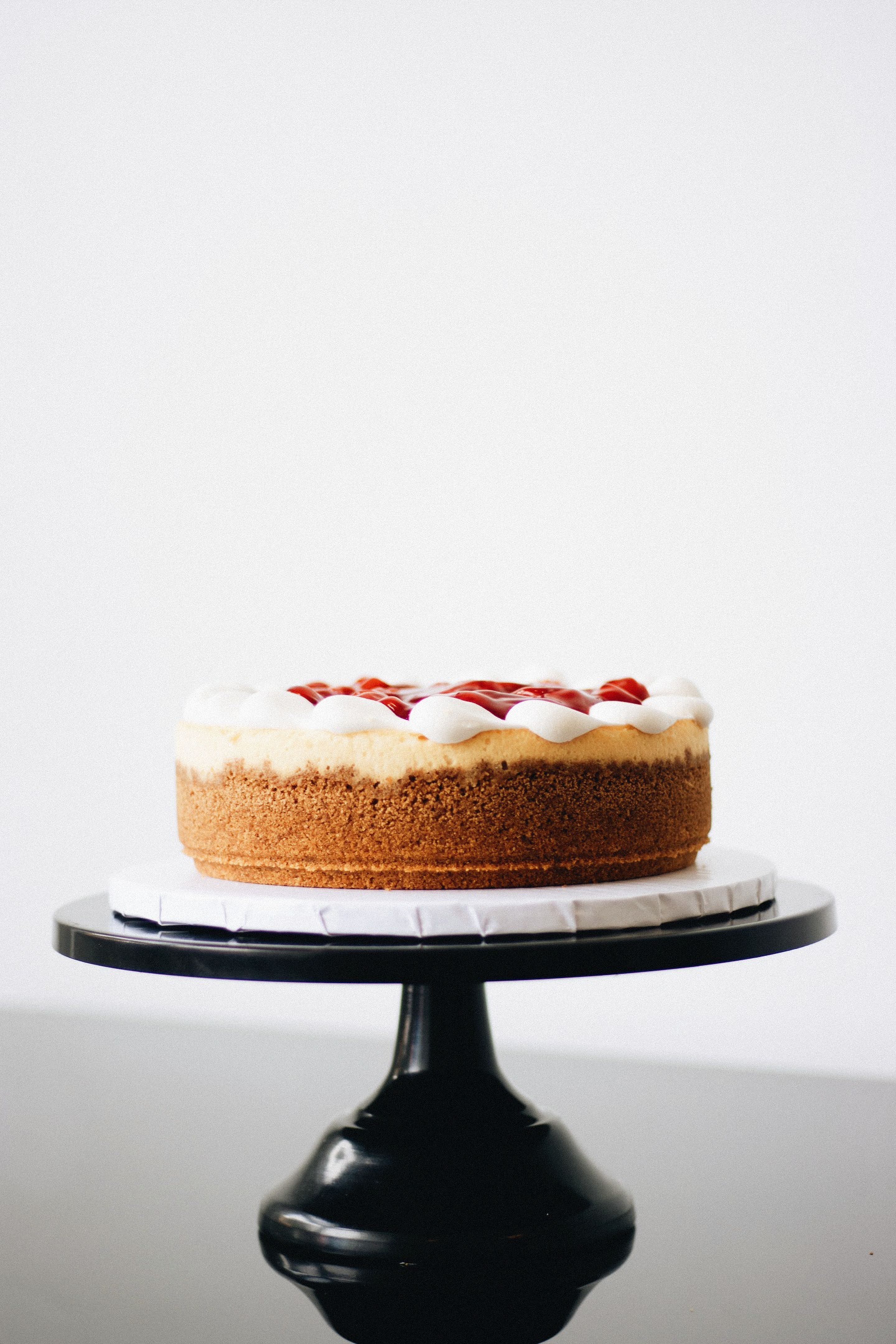 Elegant Cherry Topped Cake on Modern Stand · Free Stock Photo