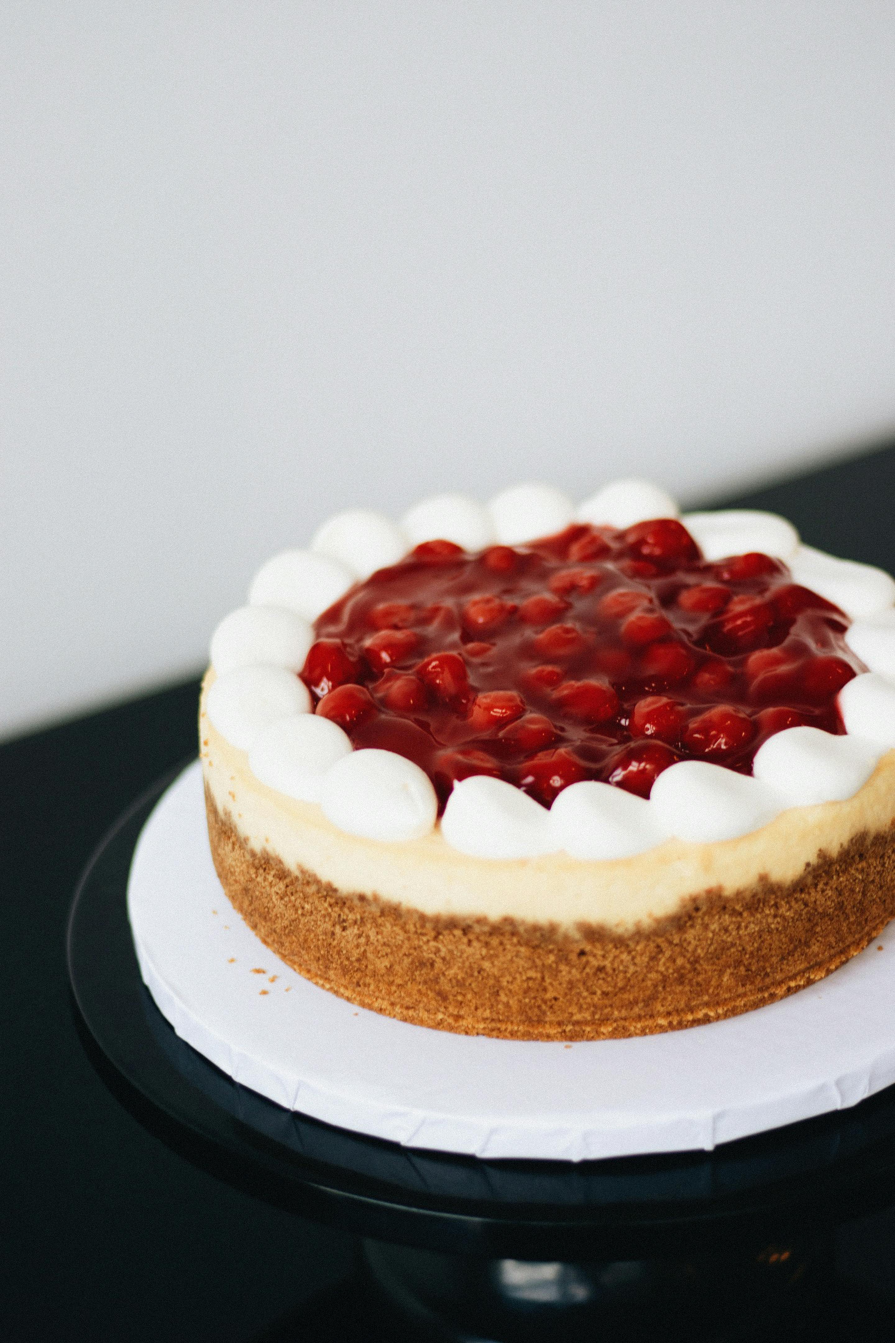 Elegant Cherry Cheesecake Display on Pedestal · Free Stock Photo