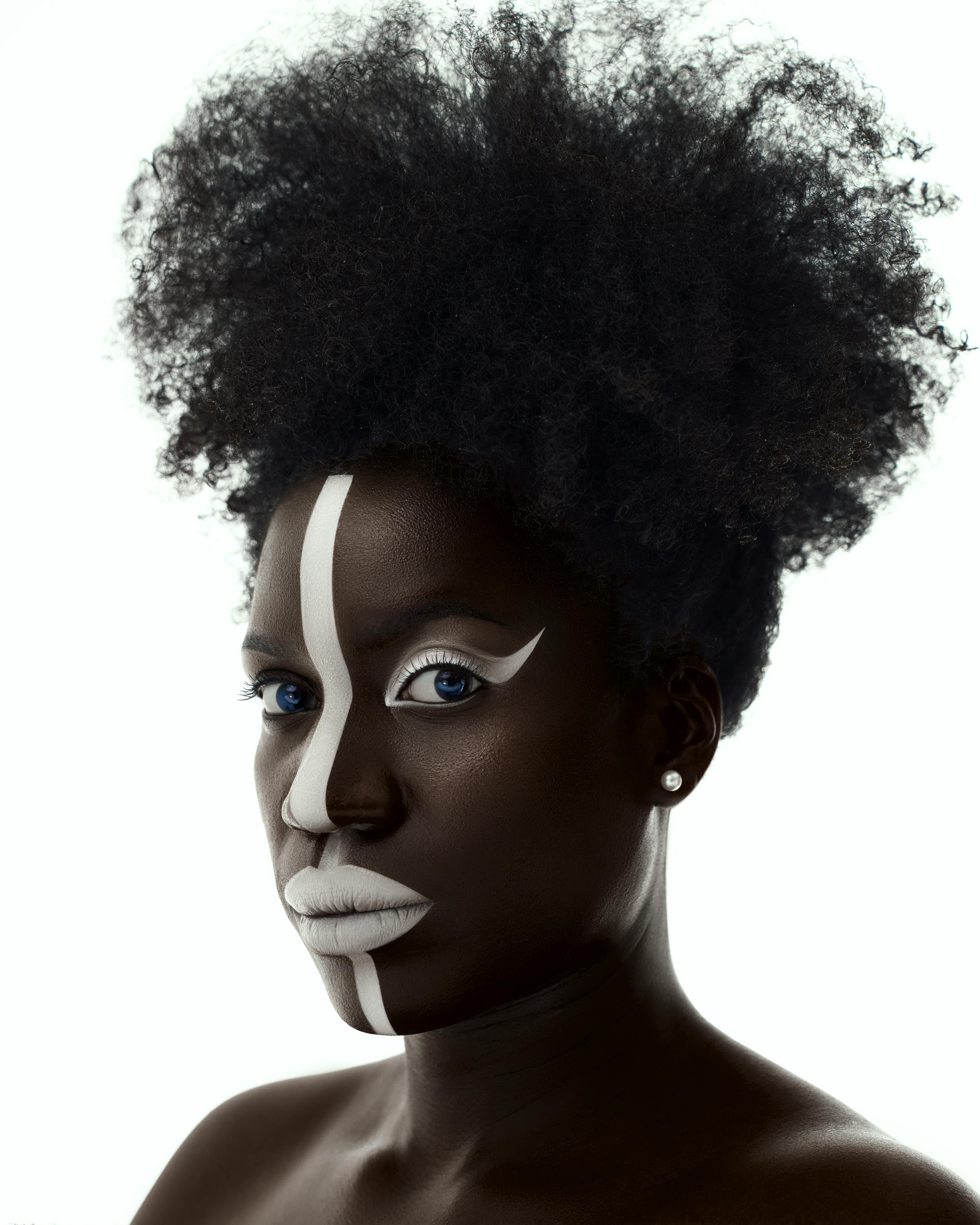 Striking Portrait of Woman with Face Paint and Afro · Free Stock Photo