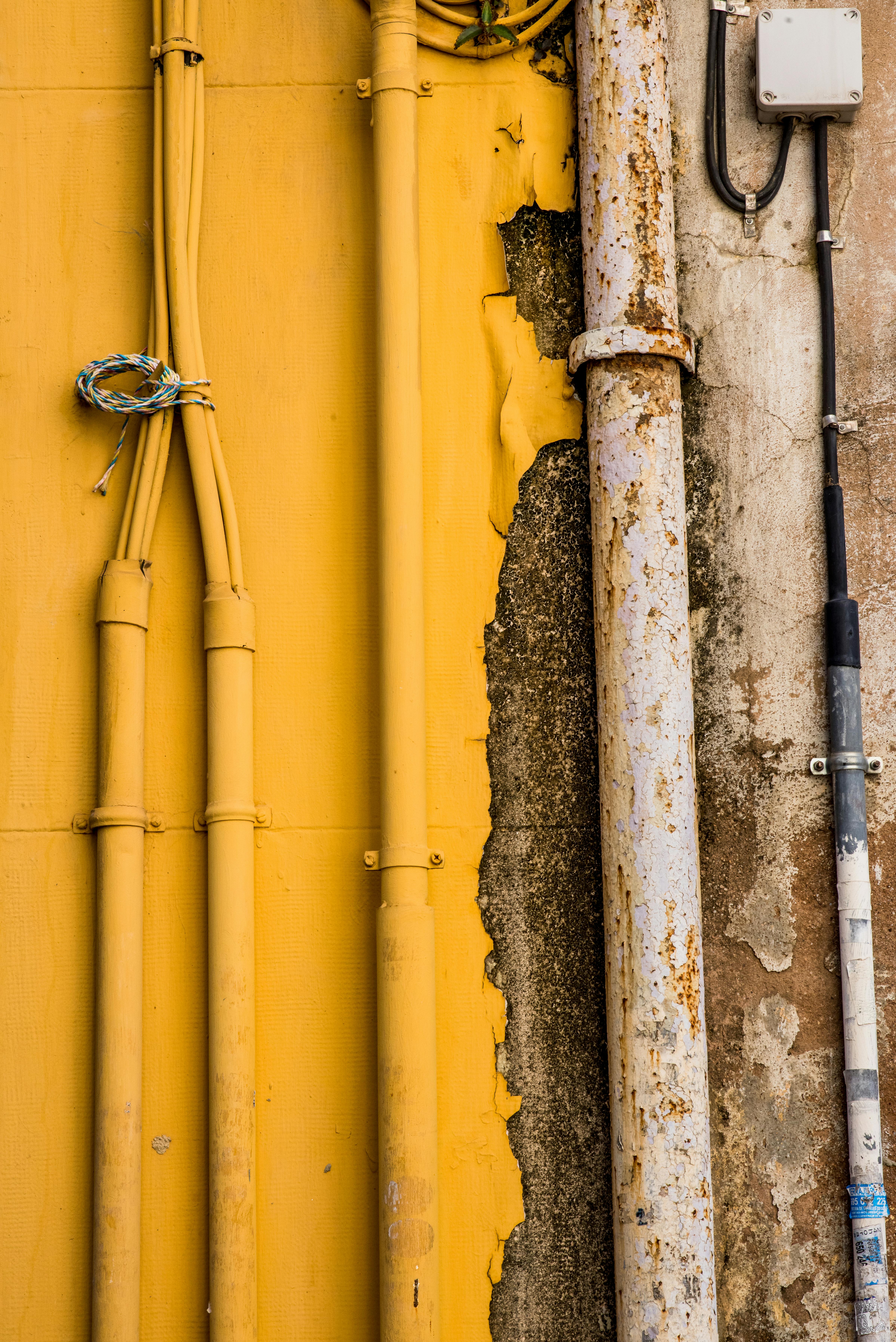 Rustic Yellow Wall with Electrical Pipes and Texture · Free Stock Photo