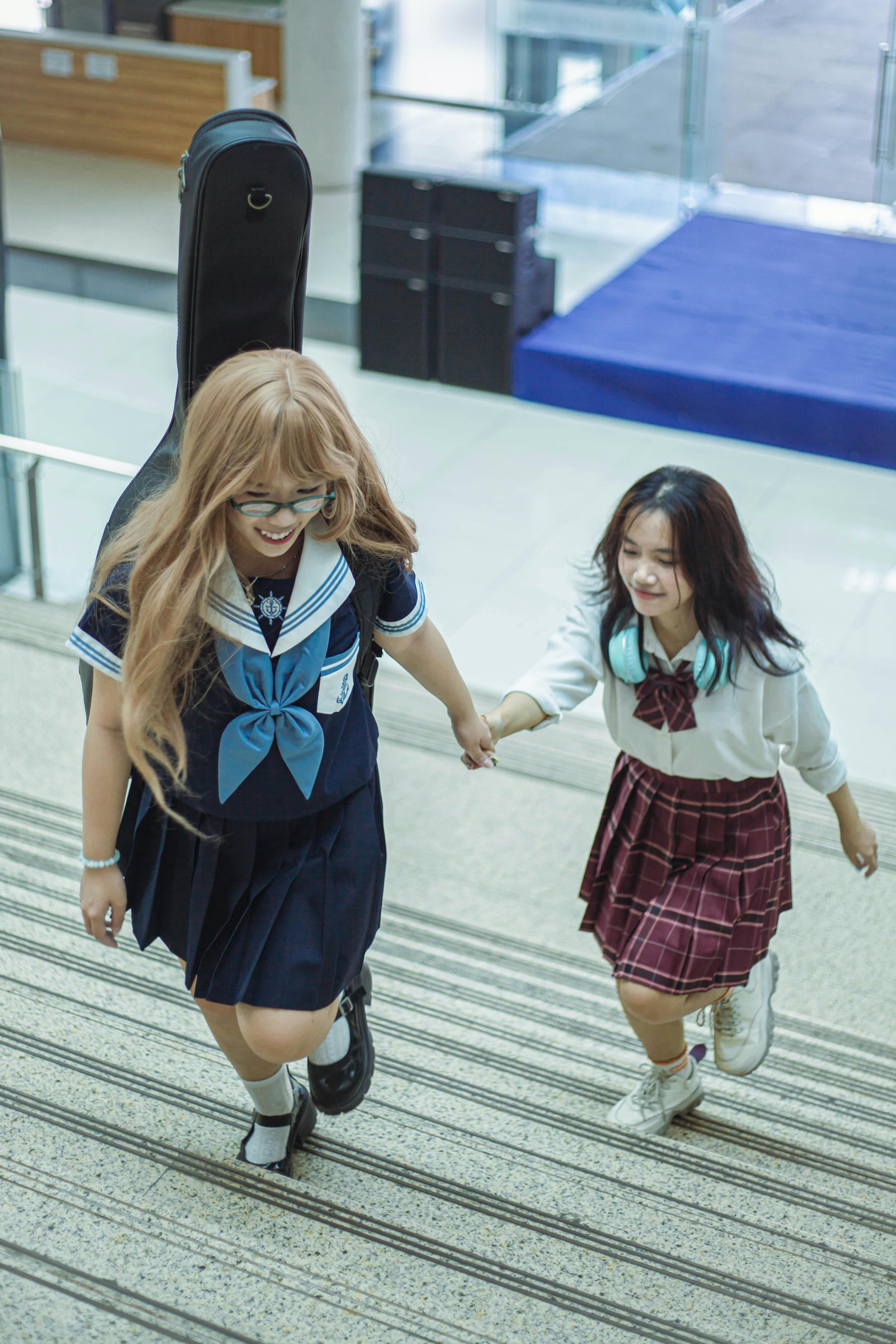 Two Girls in School Uniforms Climbing Stairs · Free Stock Photo