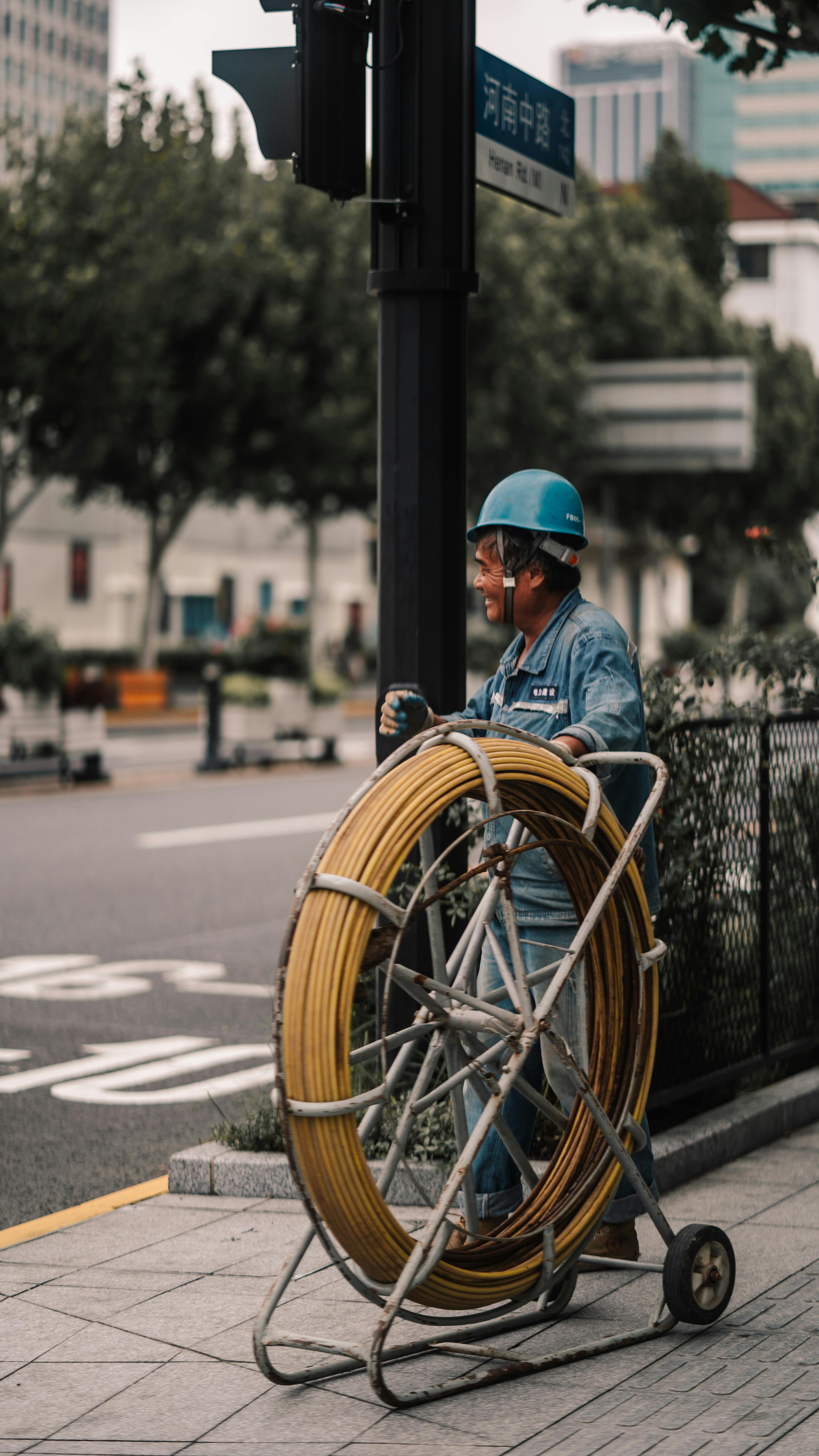 Street Worker with Cable Equipment in Urban Area · Free Stock Photo
