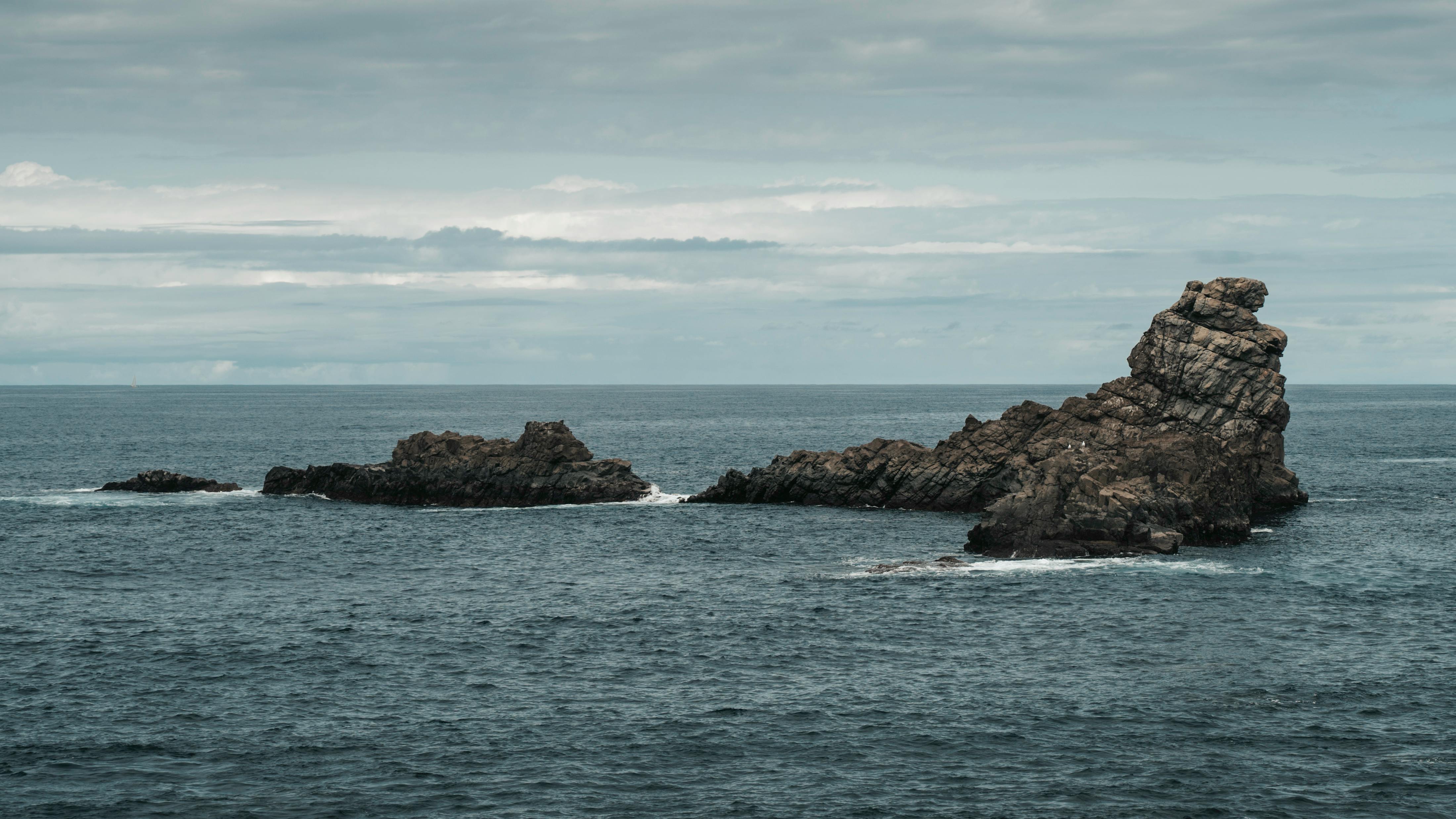 Rocky Ocean Formation Under Cloudy Sky · Free Stock Photo