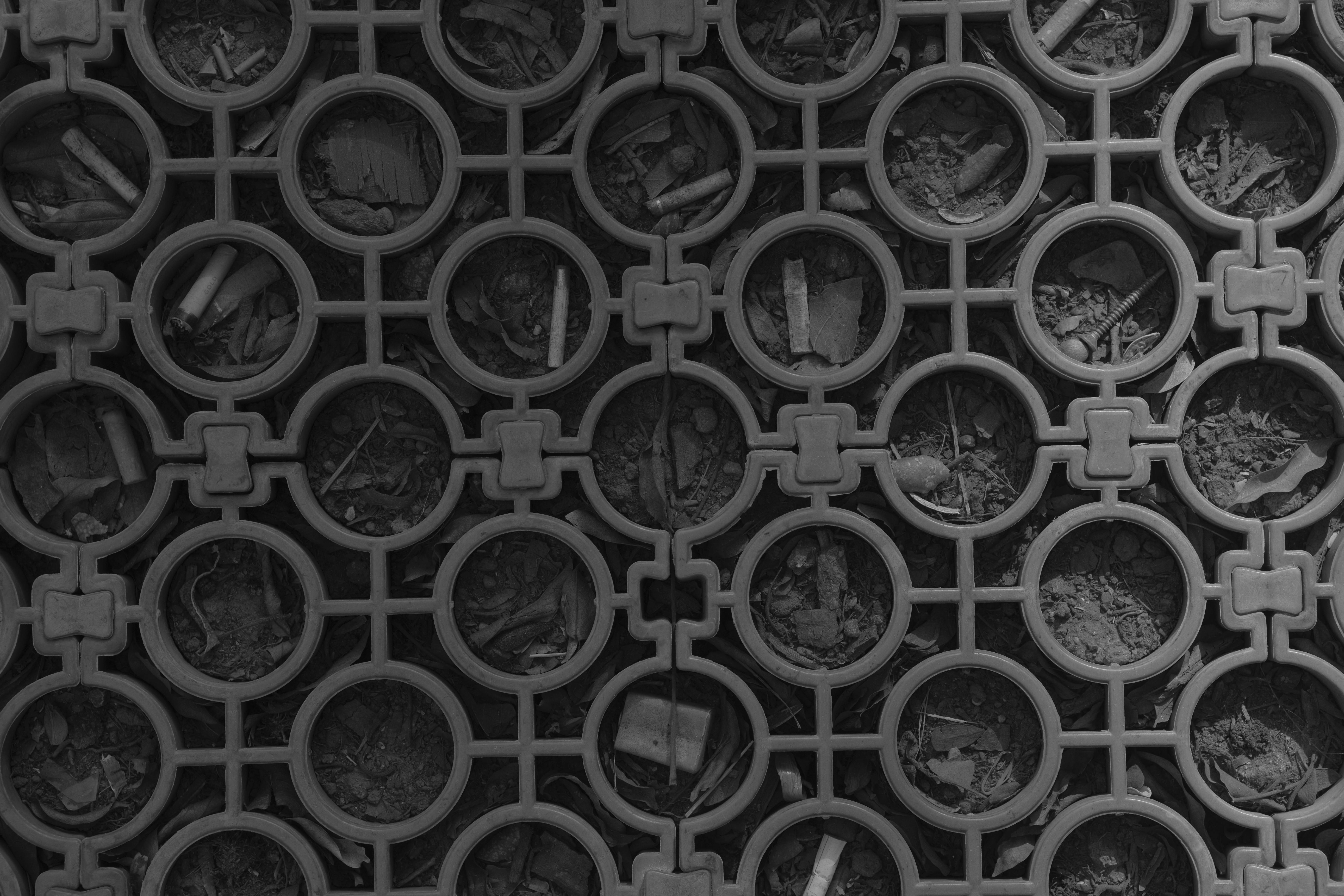 Geometric Patterned Grate with Litter Background · Free Stock Photo