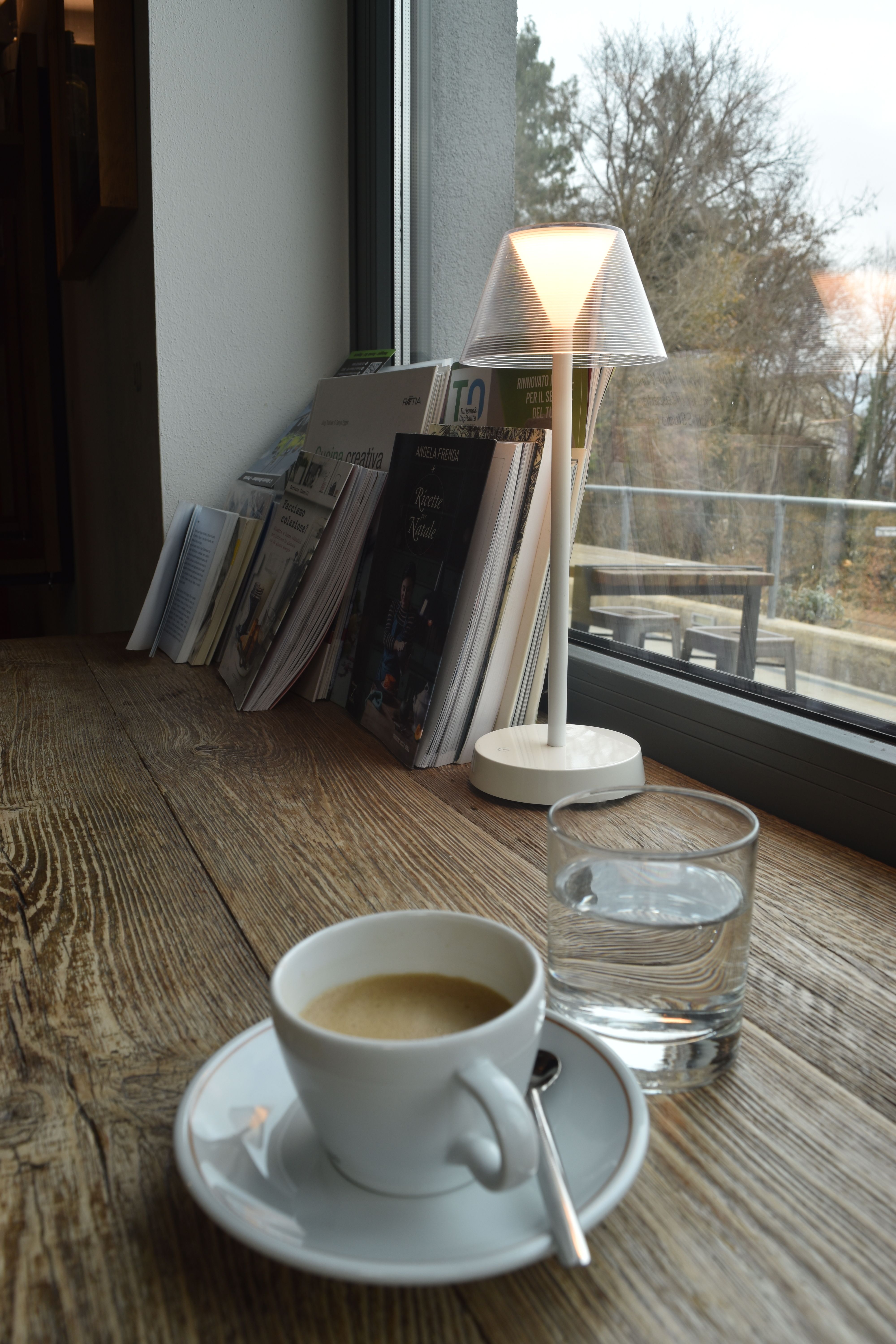 Cozy Café Window Table with Coffee and Magazines · Free Stock Photo