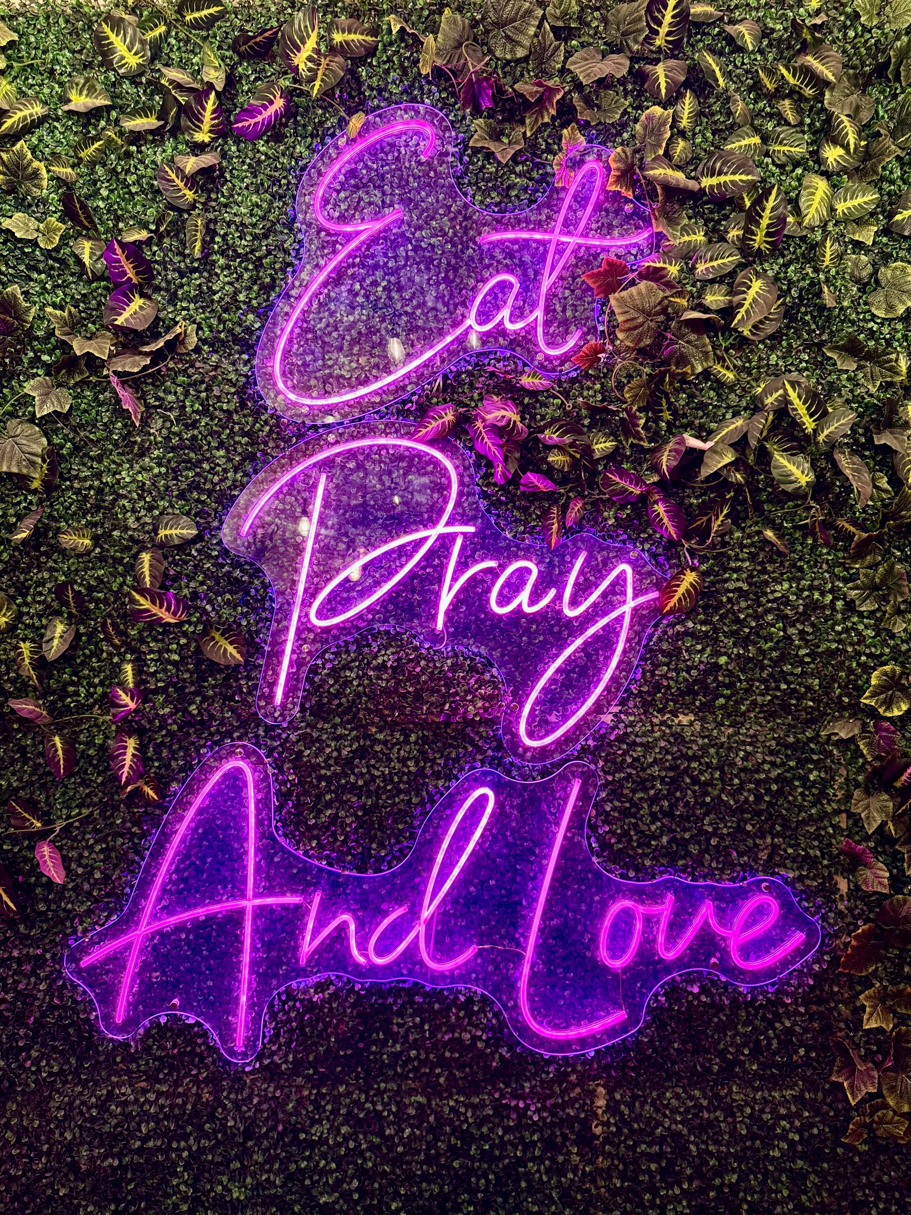 Vibrant Neon Sign 'Eat Pray And Love' on Leafy Background · Free Stock ...