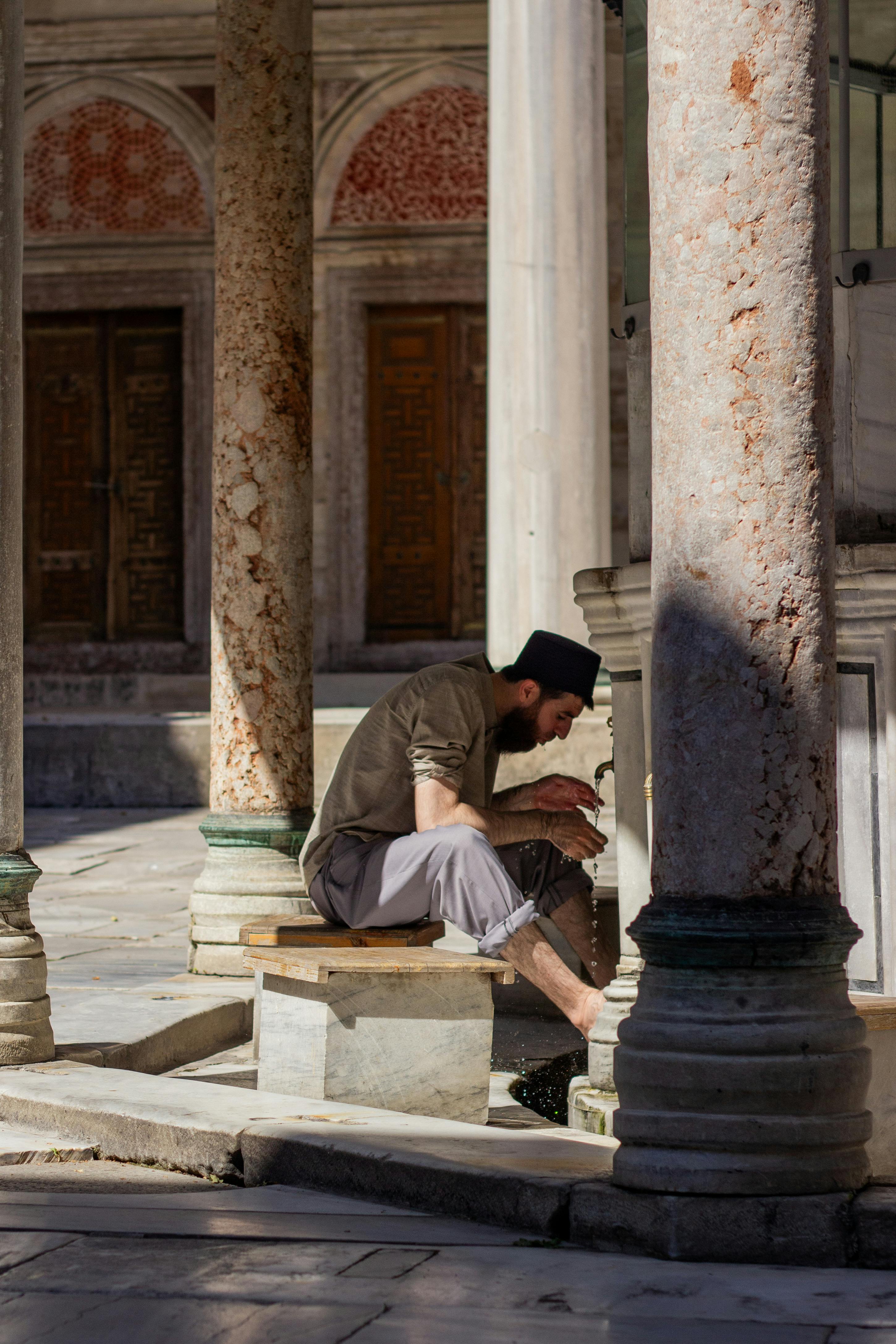 Man Performing Ritual Cleansing at Historical Site · Free Stock Photo