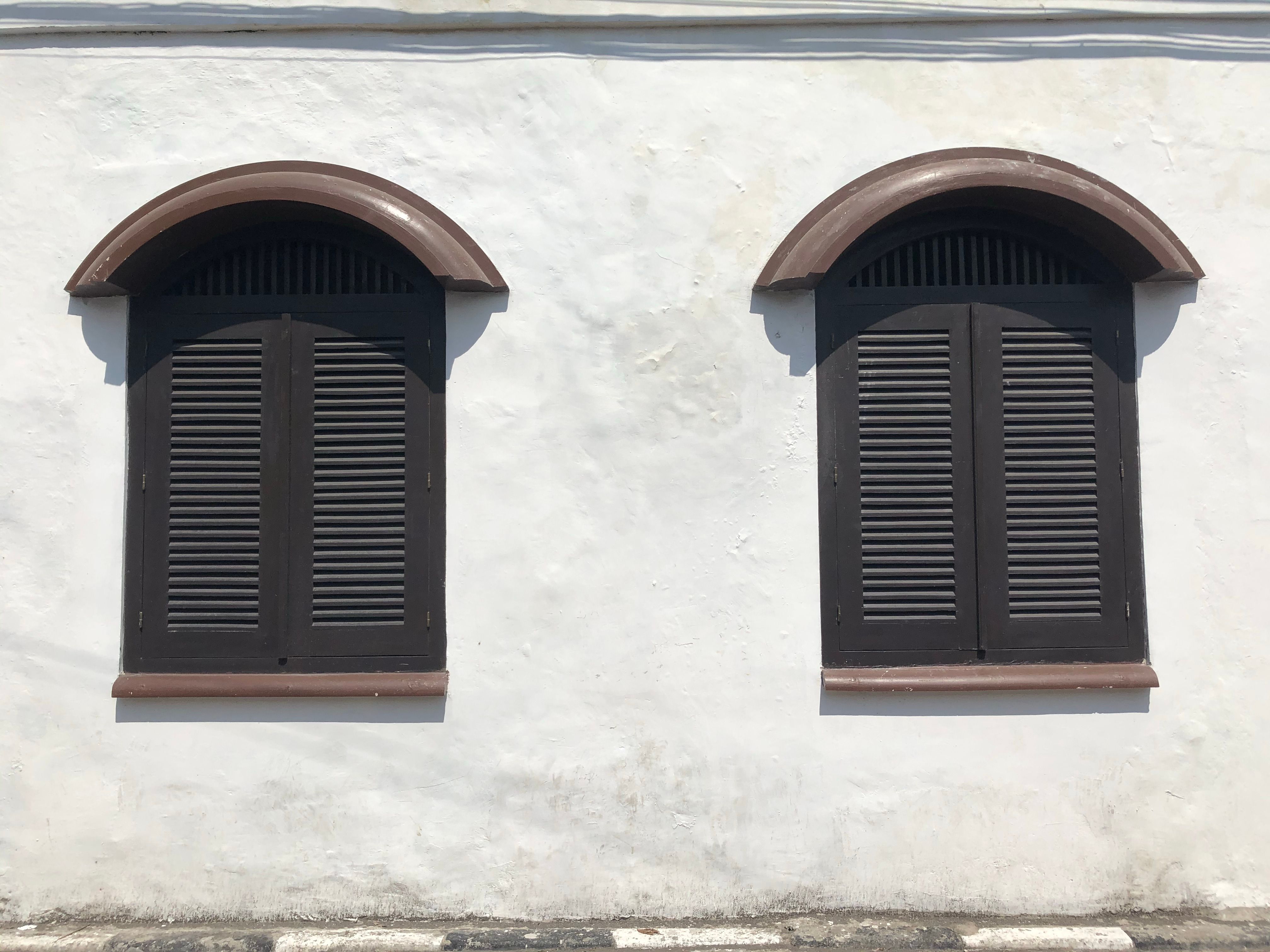 Classic Arched Wooden Shuttered Windows on White Wall · Free Stock Photo