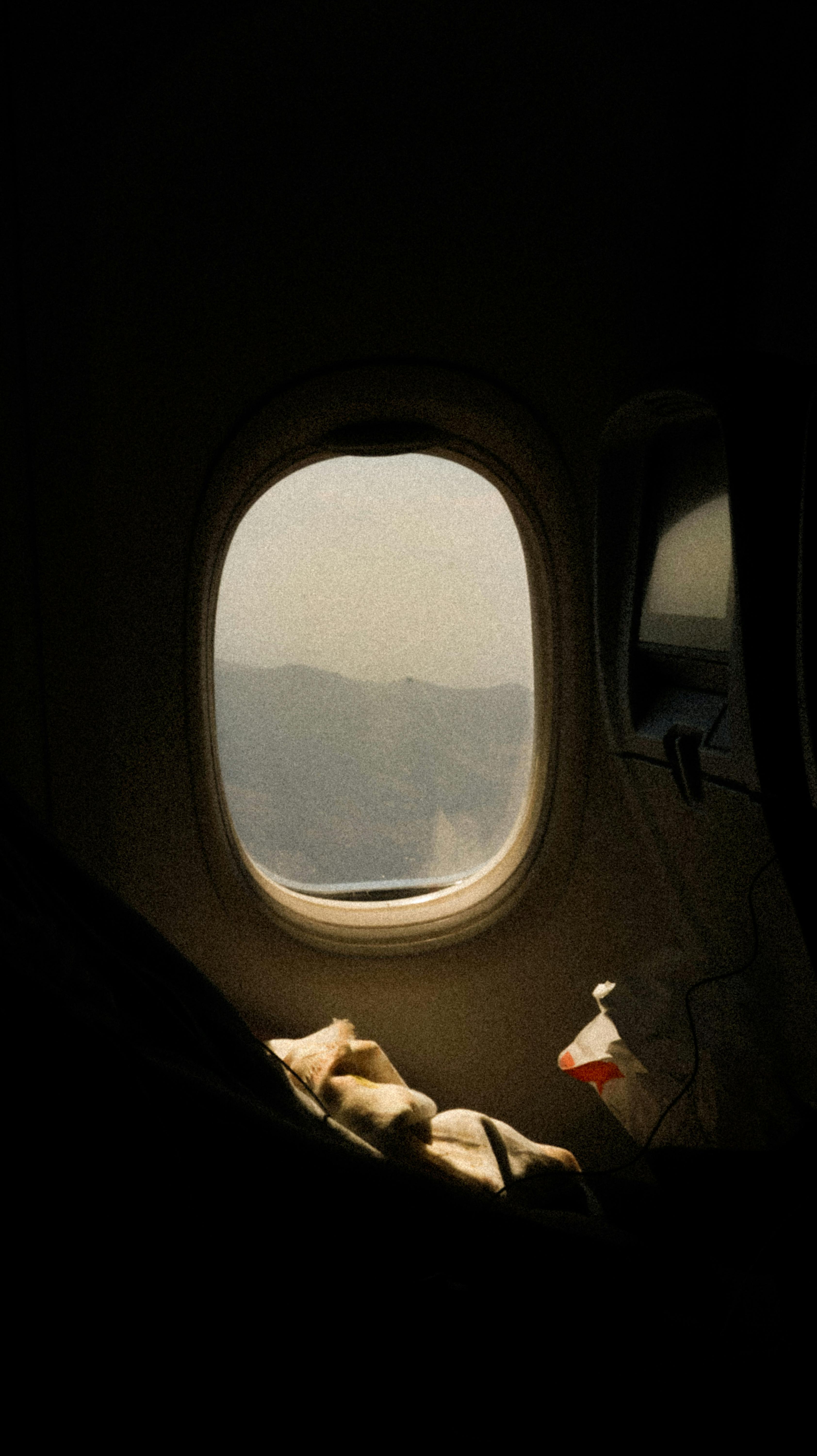 Scenic Airplane Window View Over Mountains · Free Stock Photo