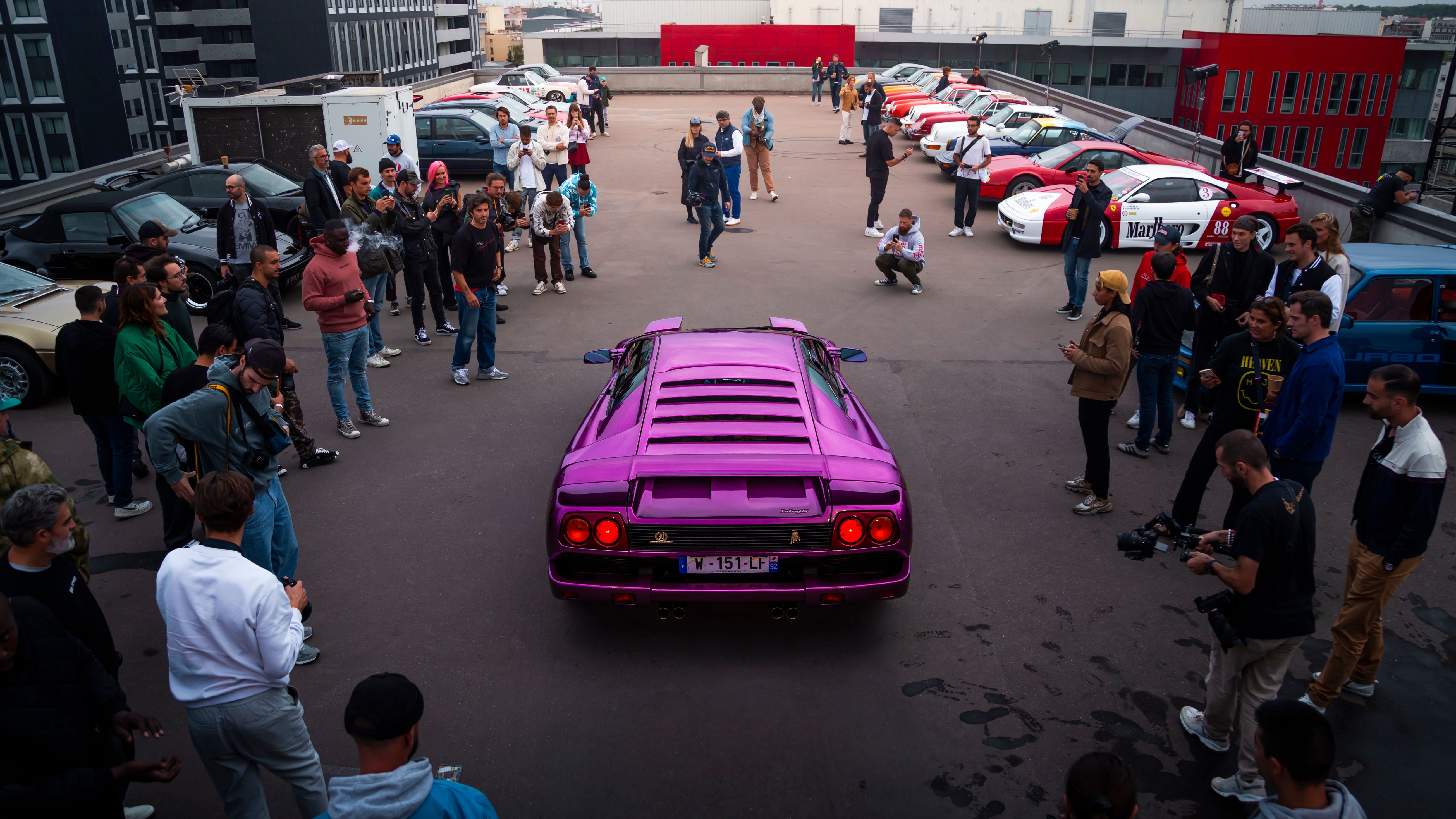 Vibrant Car Gathering on Rooftop Parking Lot · Free Stock Photo