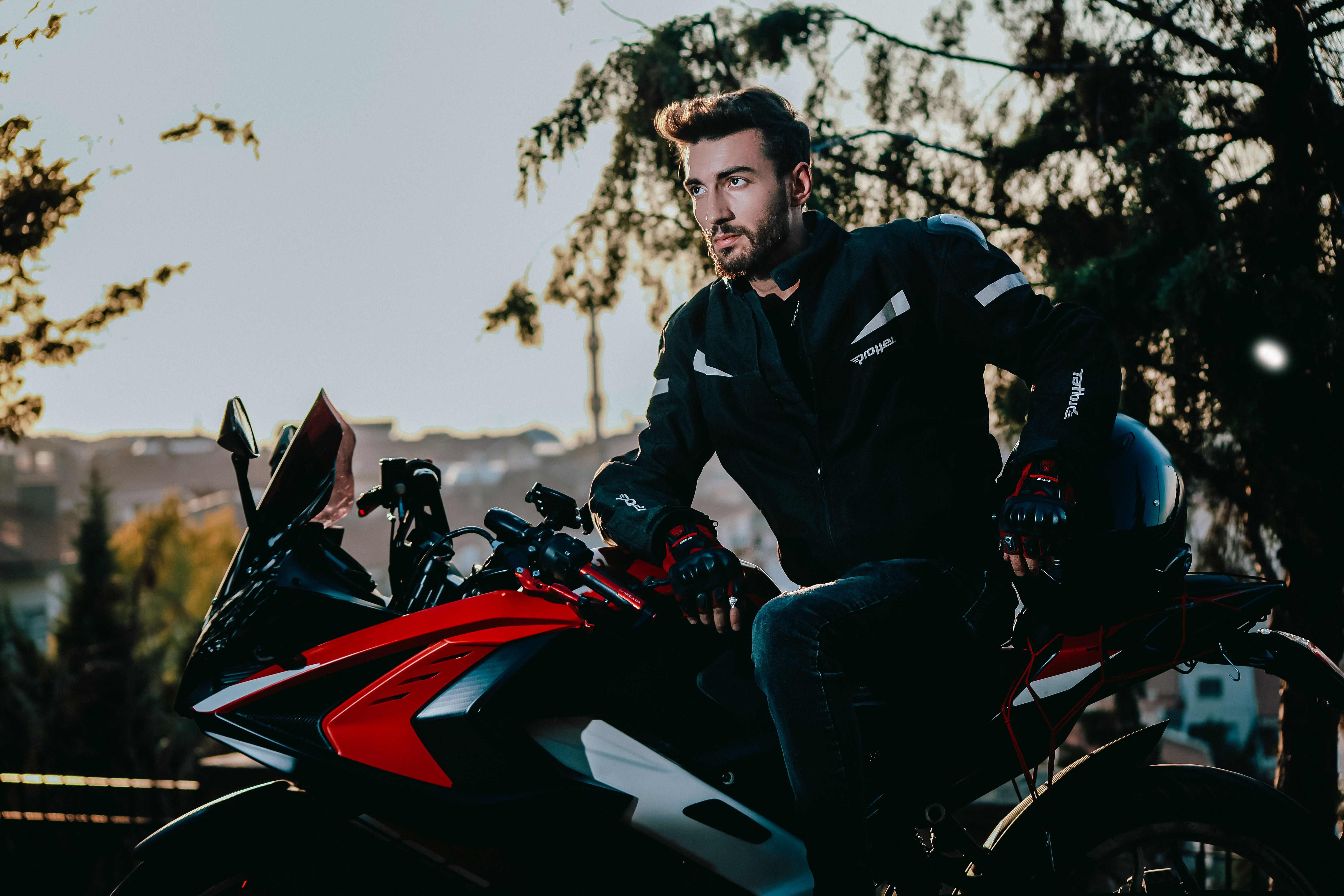 Male Biker Posing with Motorcycle in Scenic Outdoors · Free Stock Photo