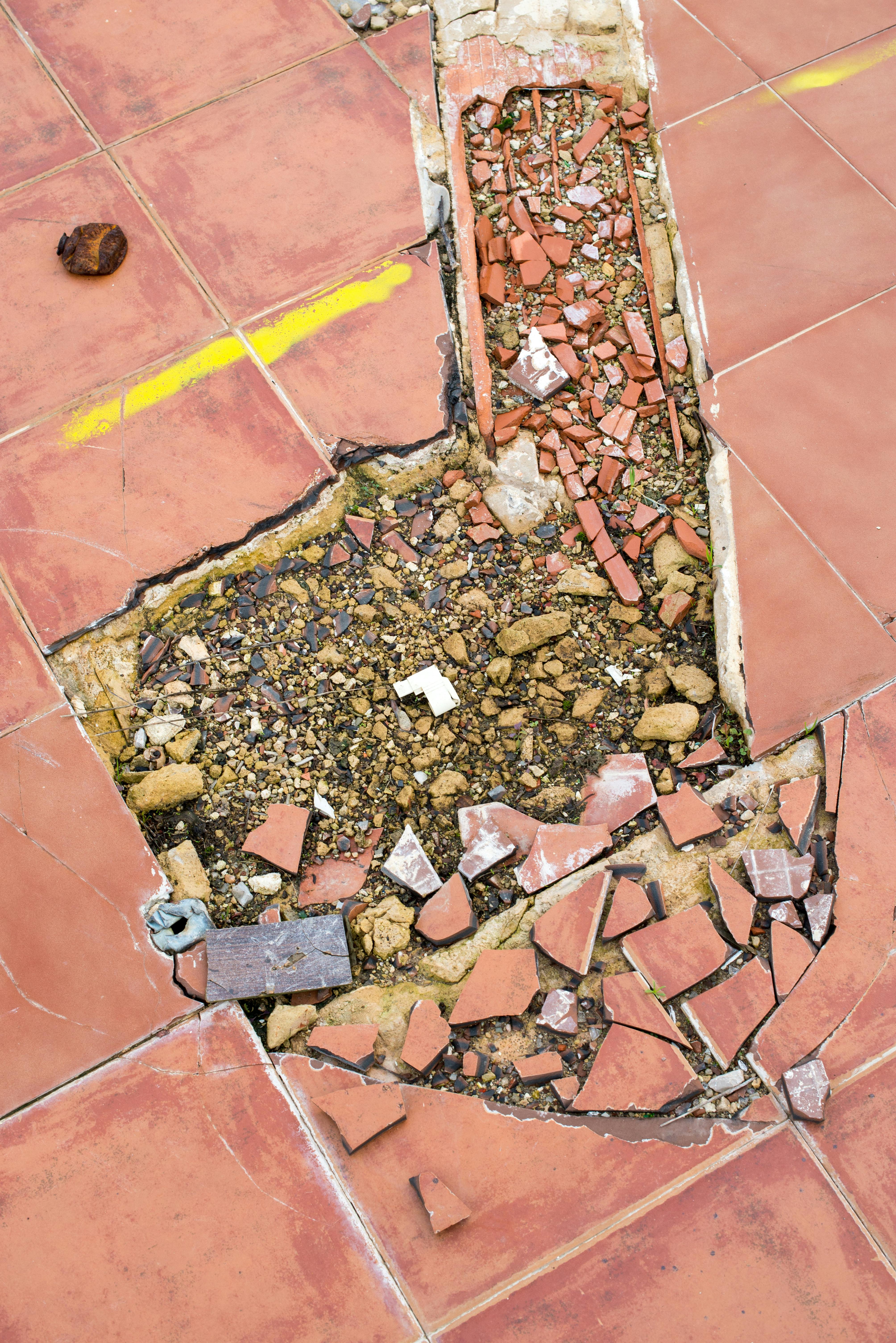 Damaged Tile Floor with Exposed Debris · Free Stock Photo