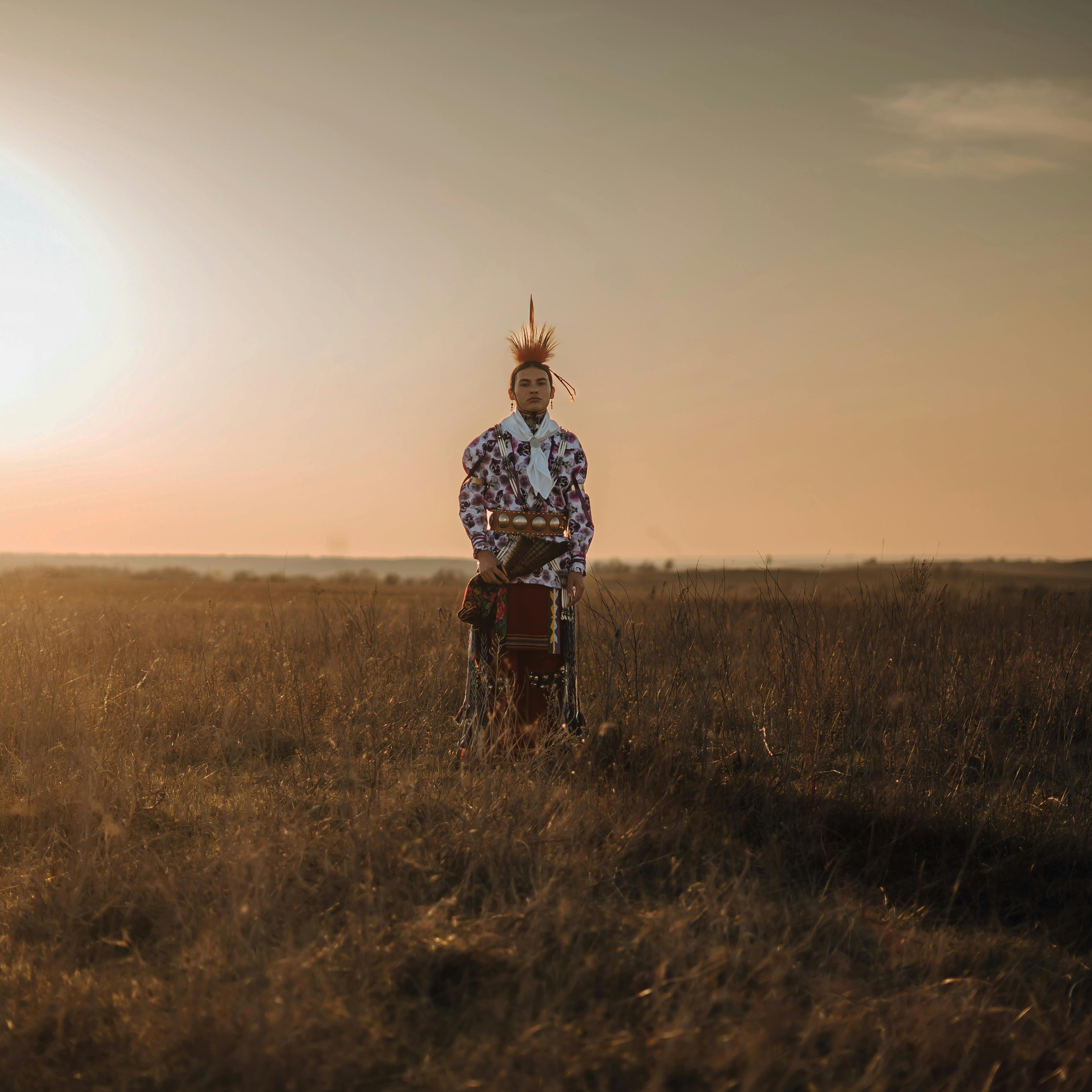 Indigenous Ceremonial Attire in Sunset Field · Free Stock Photo