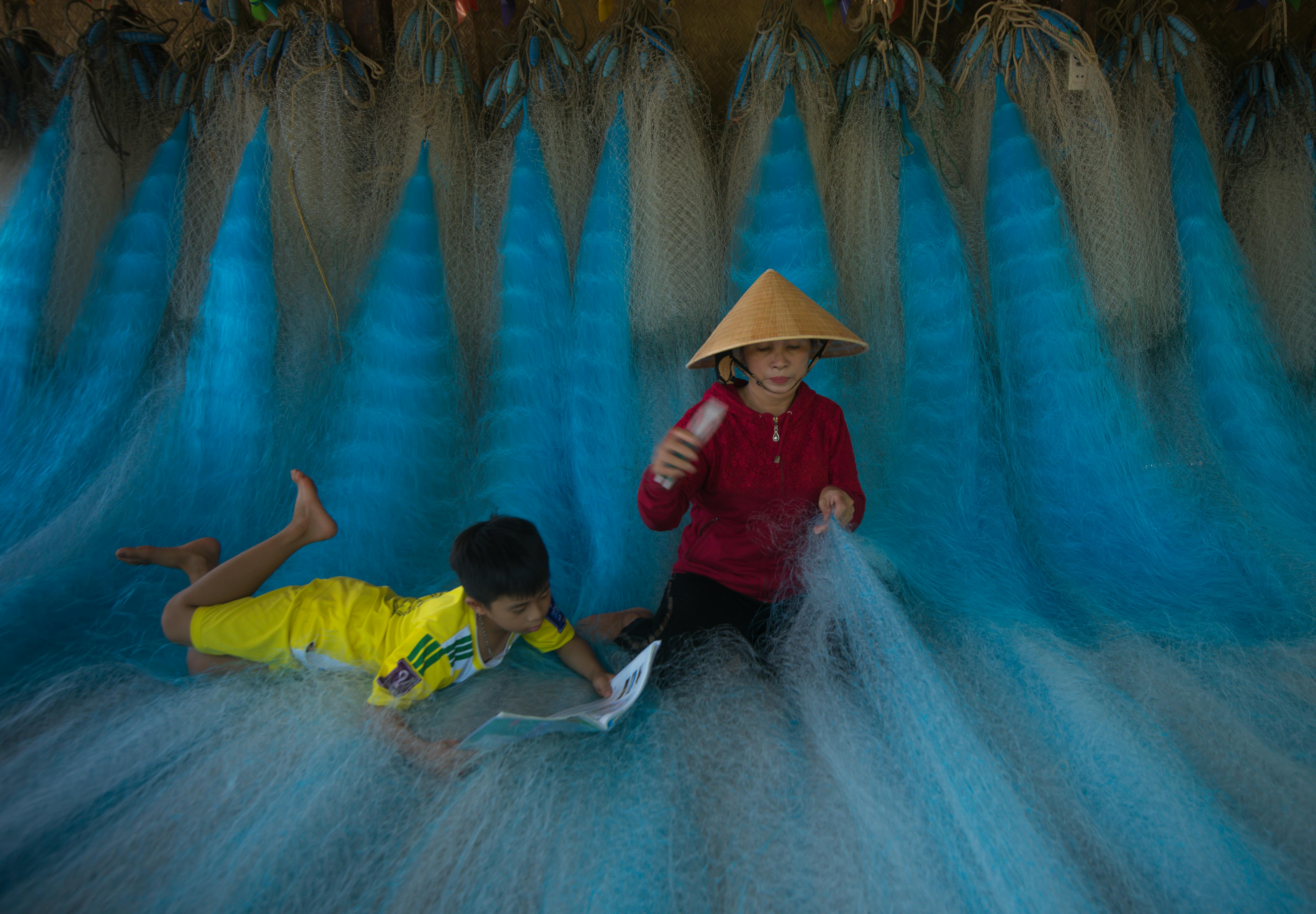 Mother and Child Weaving Fishing Nets Together · Free Stock Photo