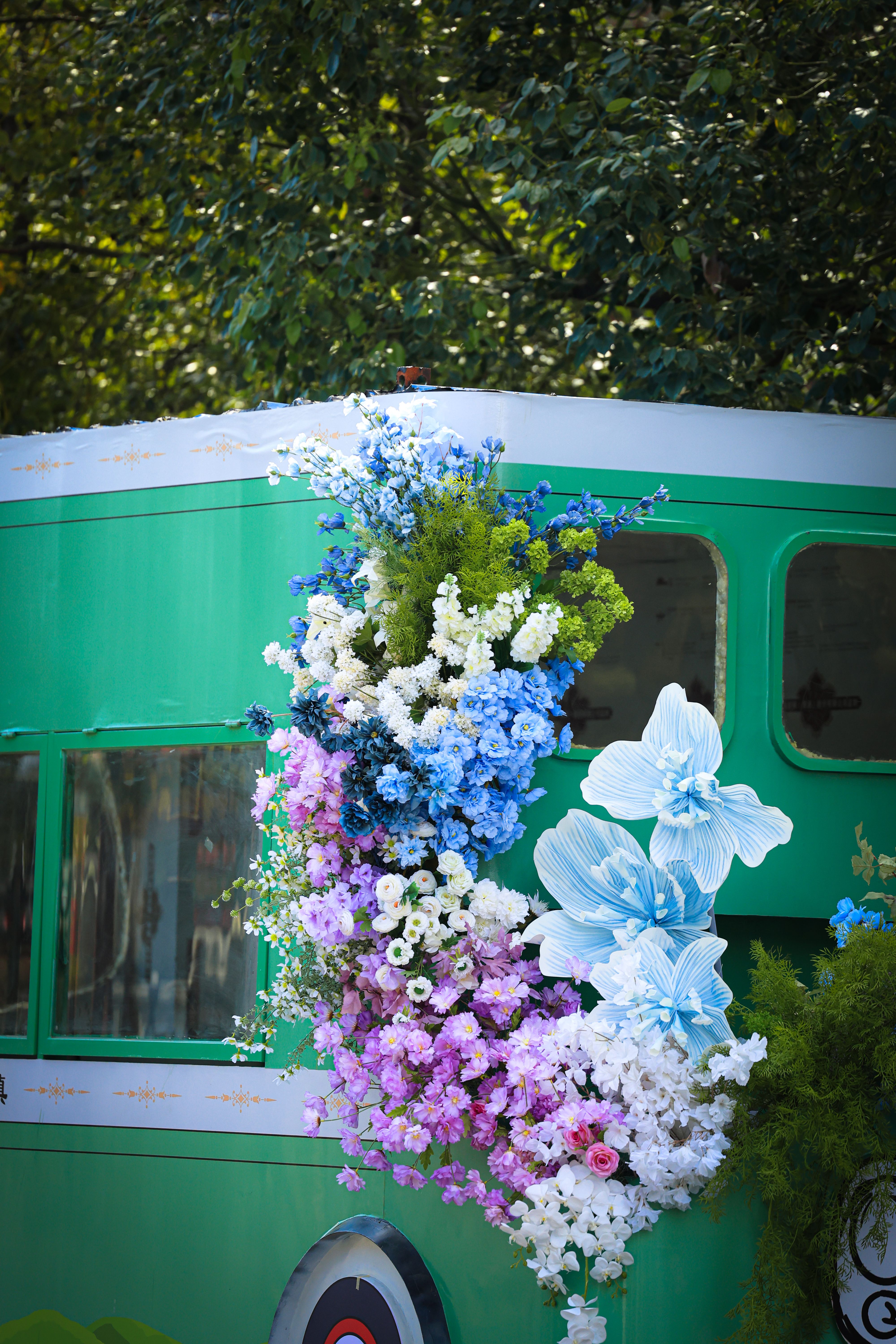 Colorful Floral Arrangement on Green Bus · Free Stock Photo