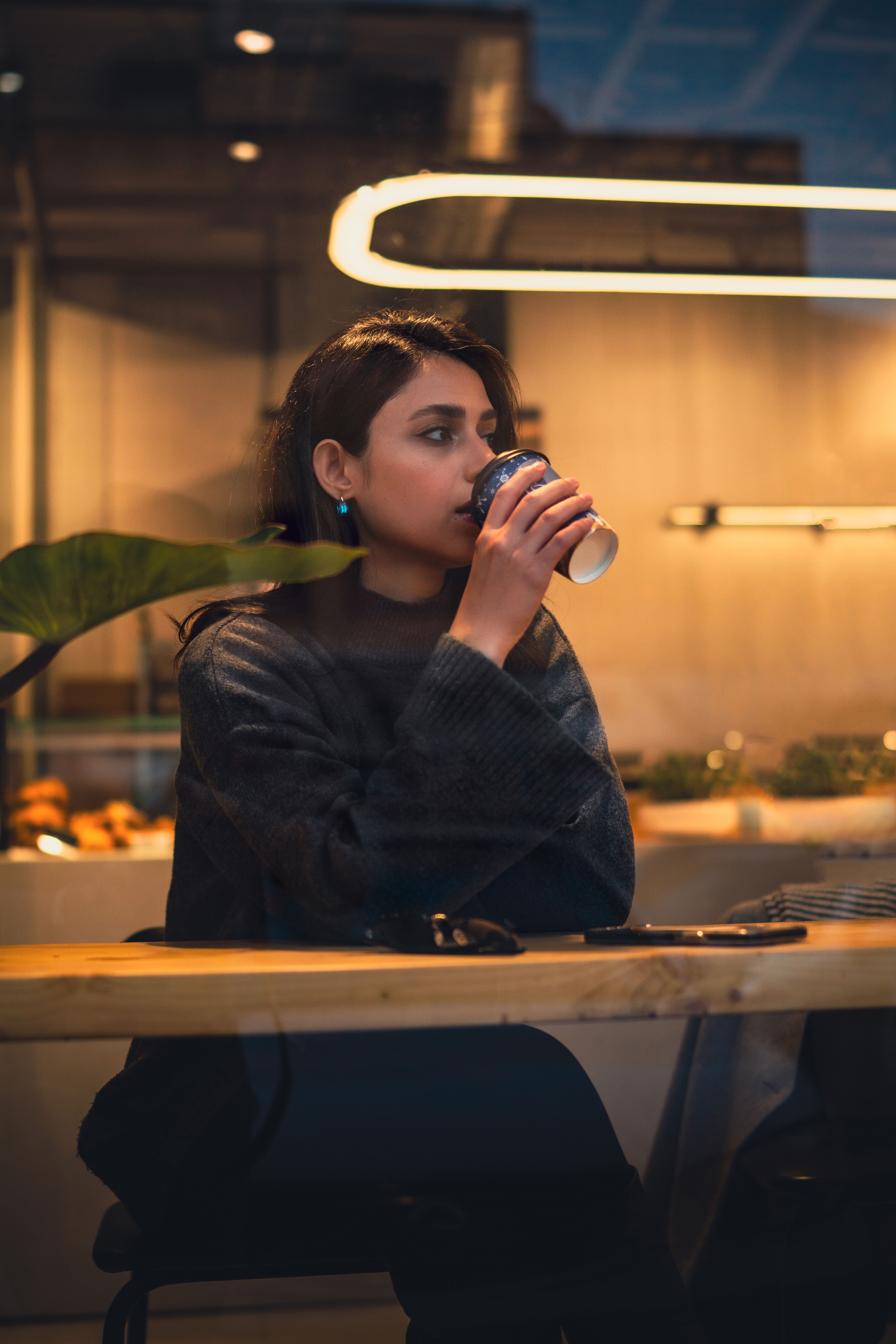 Woman Relaxing with Coffee in Cozy Café Setting · Free Stock Photo