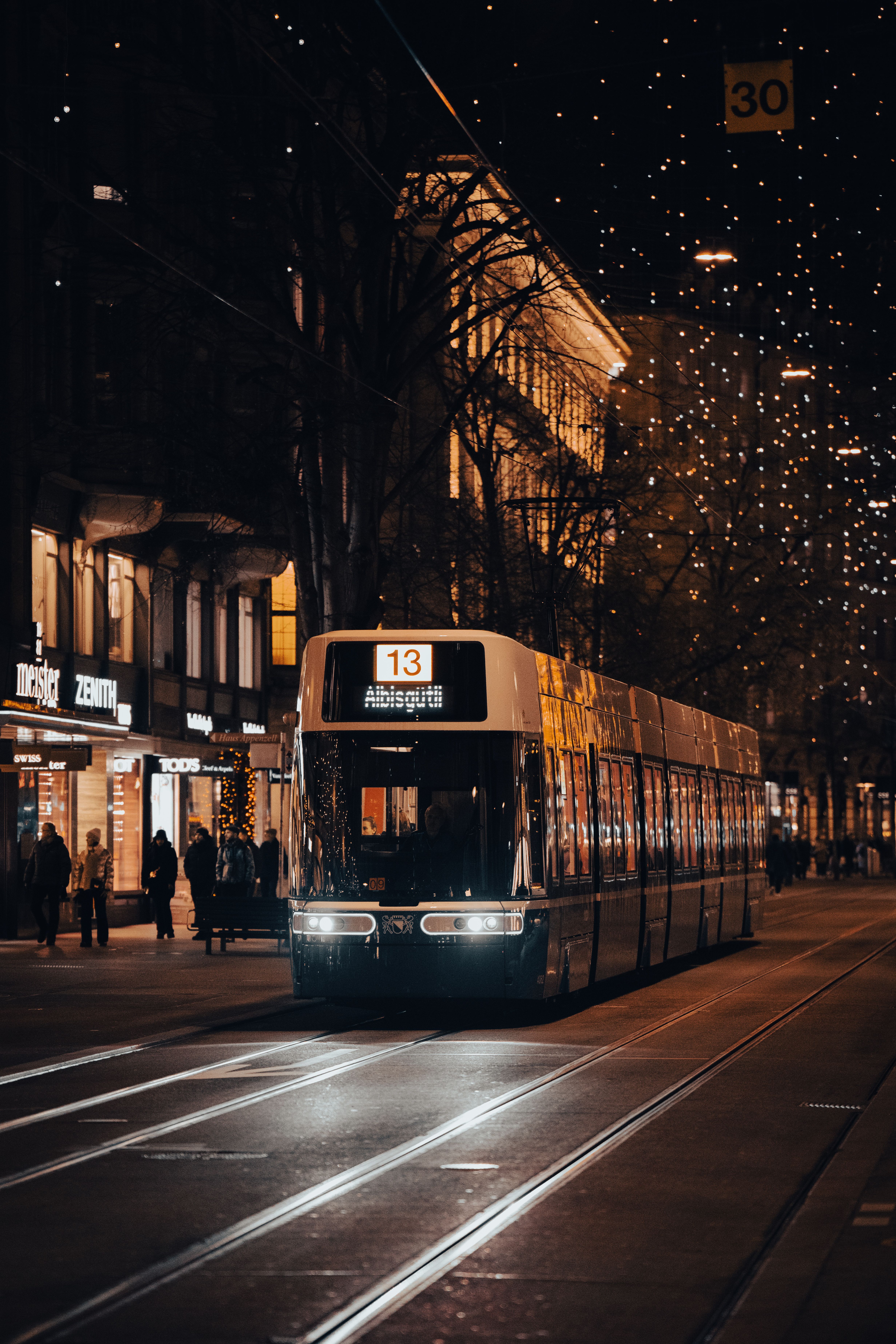 Nighttime Streetcar on Lights Adorned City Street · Free Stock Photo