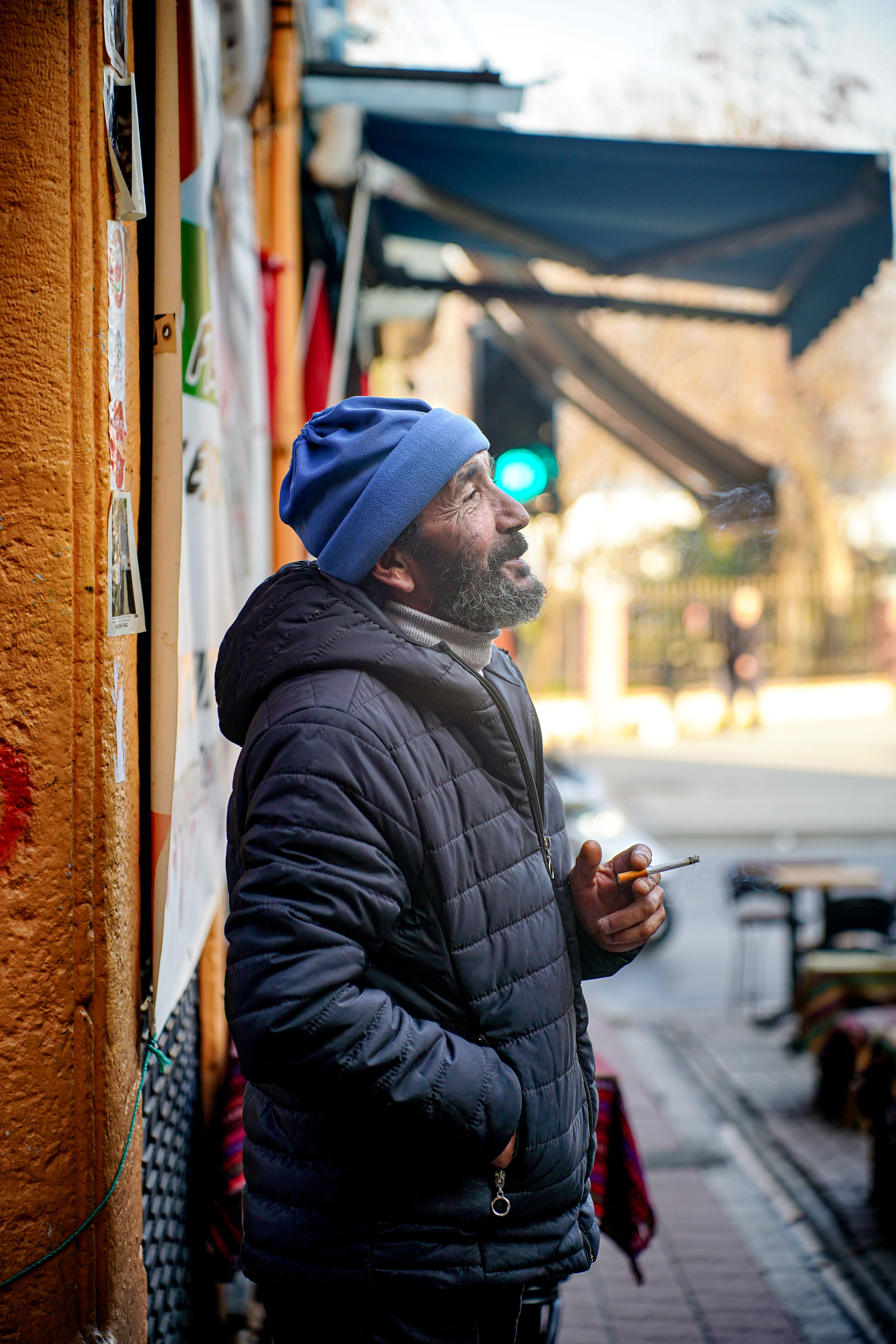 Man in Urban Setting with Blue Beanie and Cigarette · Free Stock Photo