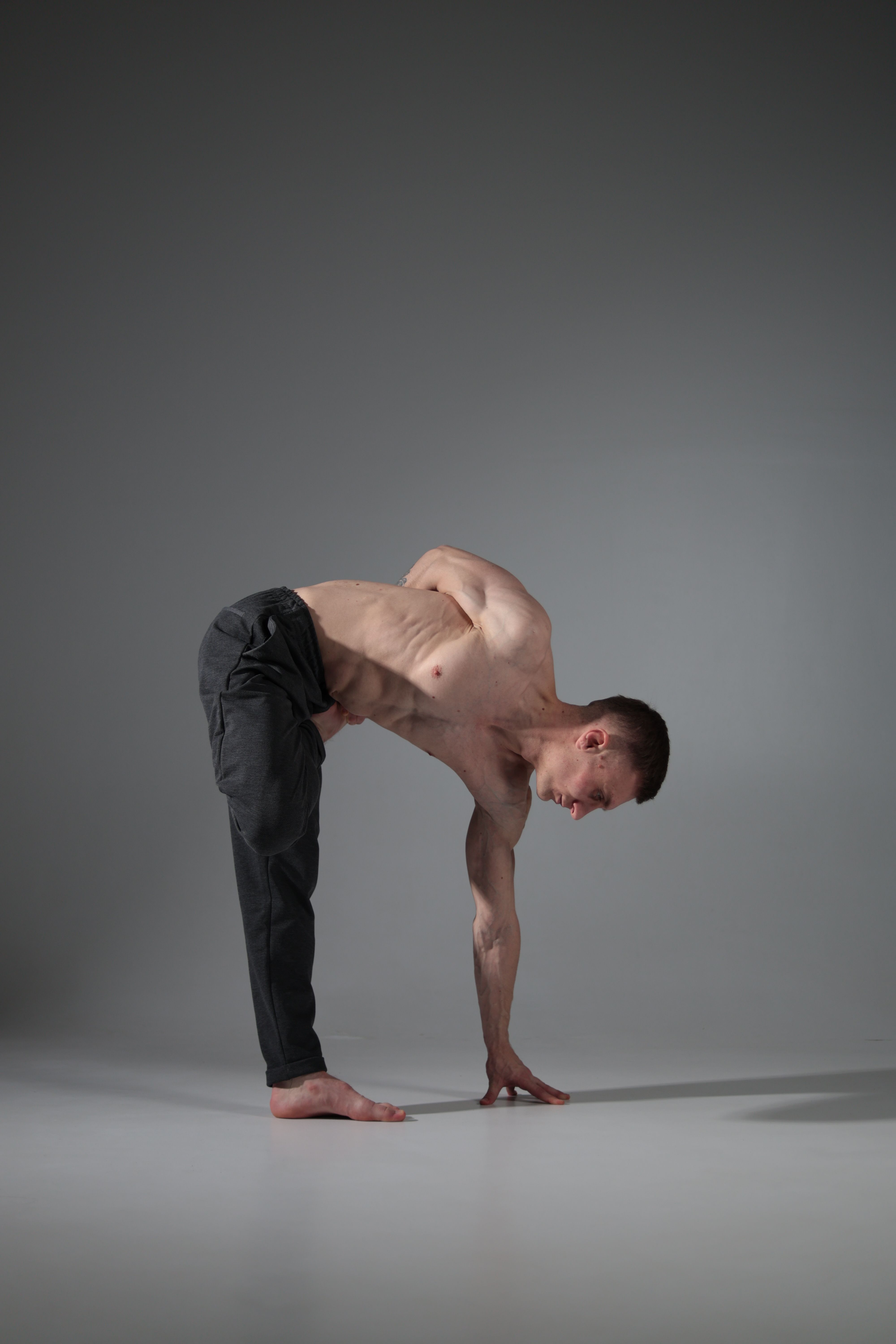Man Performing Unique Yoga Pose in Studio · Free Stock Photo