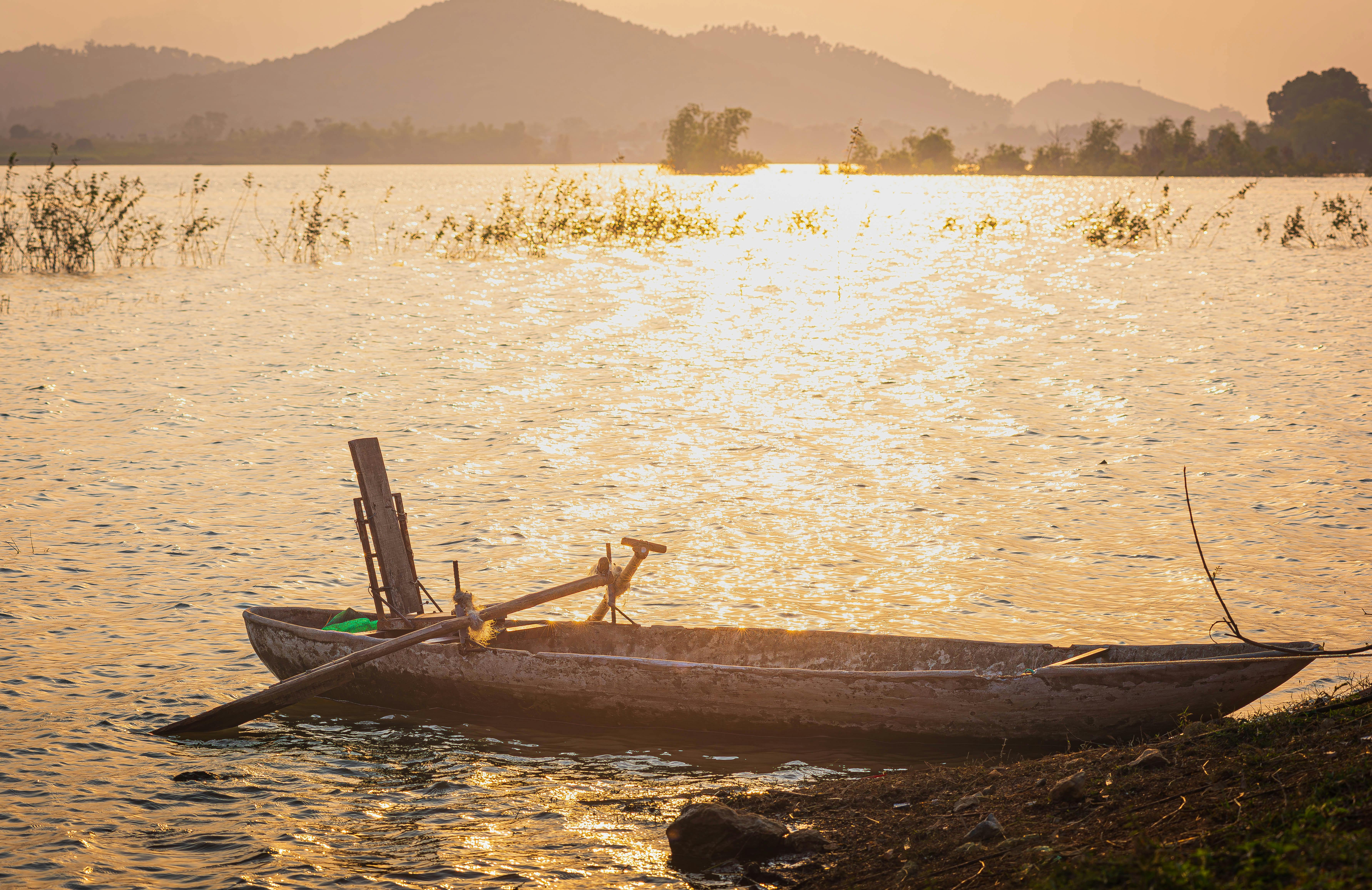 Serene Boat on Sunlit Lake at Sunset · Free Stock Photo