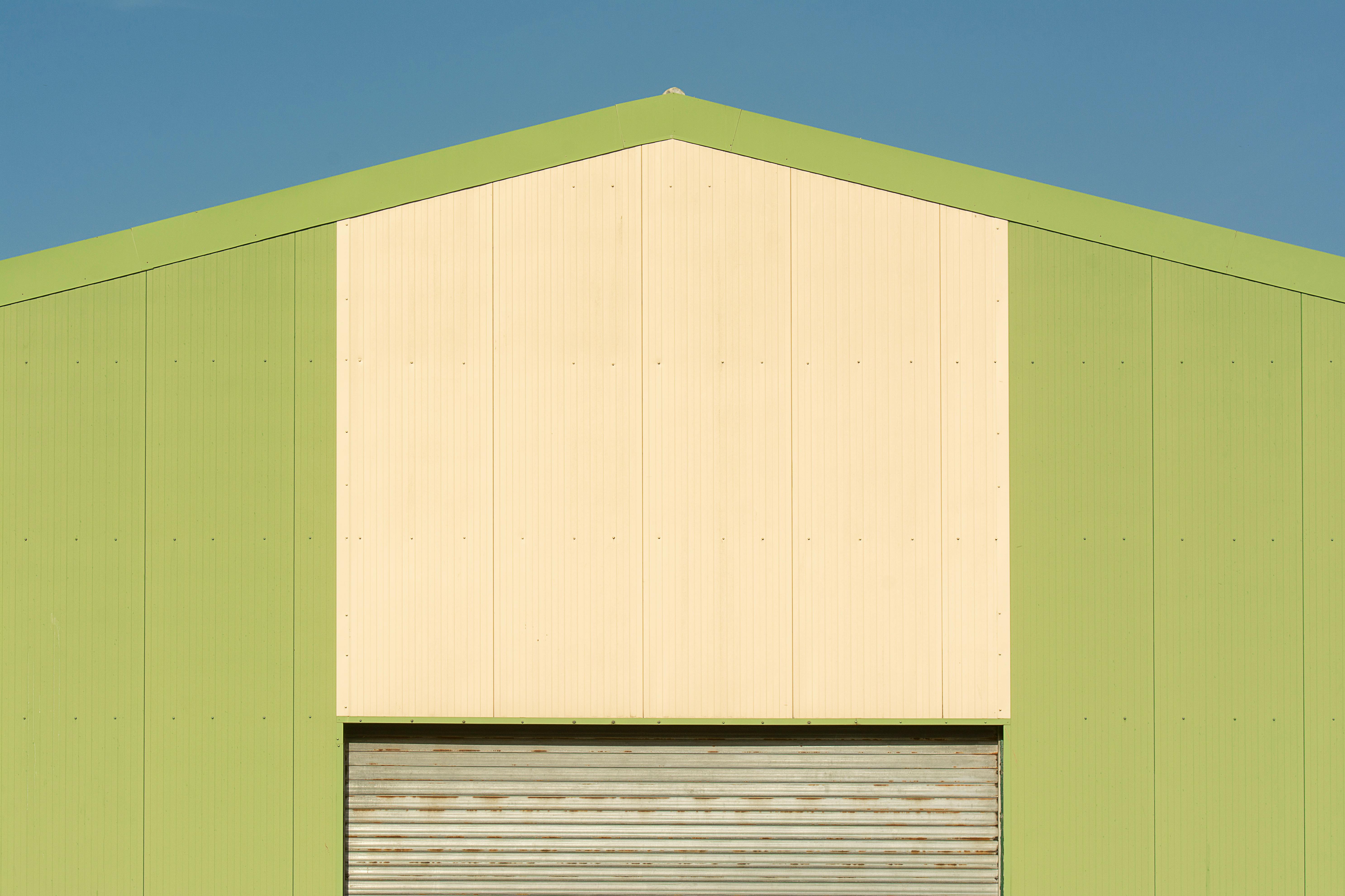 Symmetrical Green Industrial Warehouse Exterior · Free Stock Photo