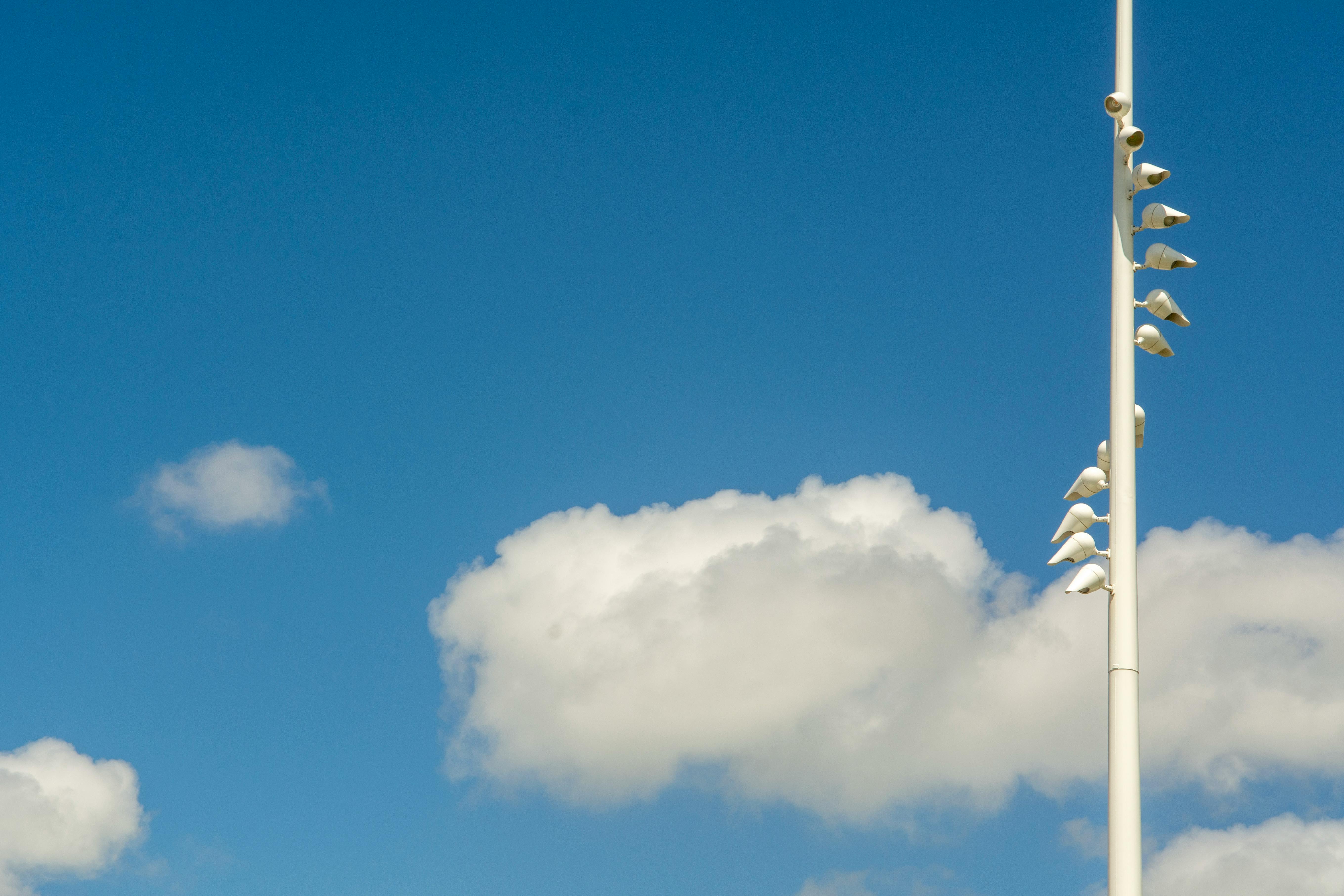 Tall Light Pole Against Blue Sky with Clouds · Free Stock Photo