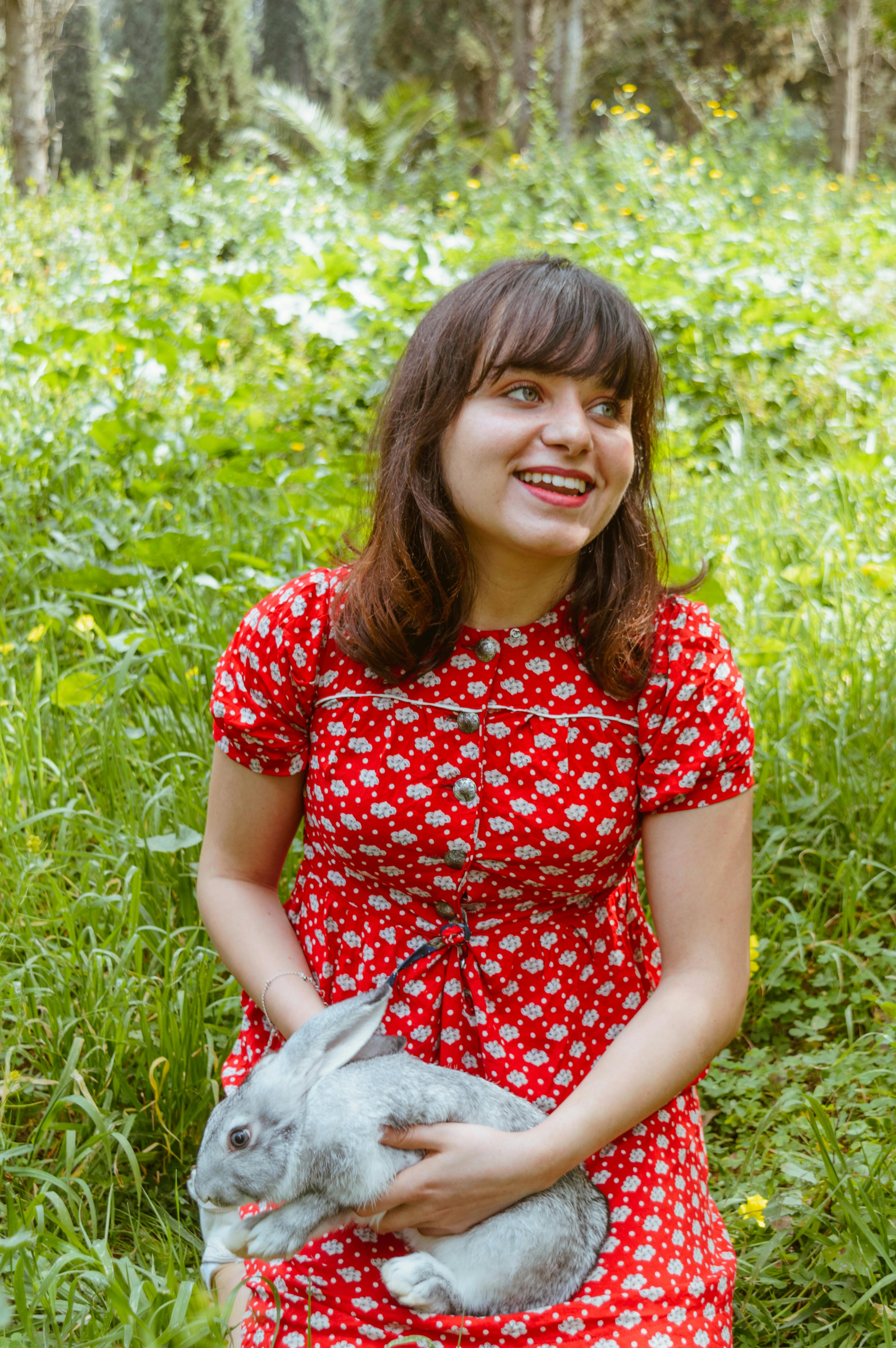 Joyful Woman Holding Rabbit in Lush Garden · Free Stock Photo
