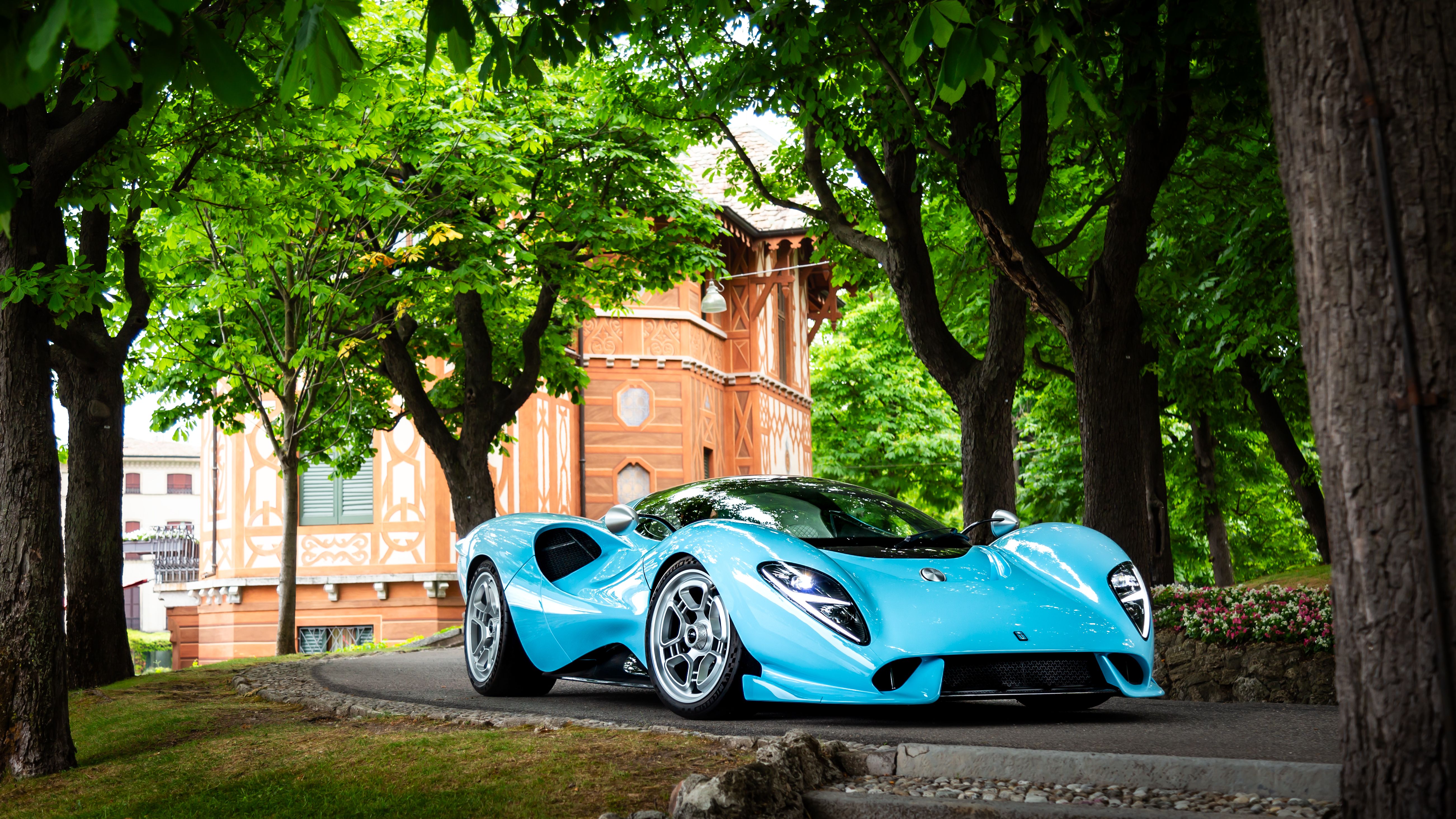 Sleek Blue Sports Car in Picturesque Garden Setting · Free Stock Photo