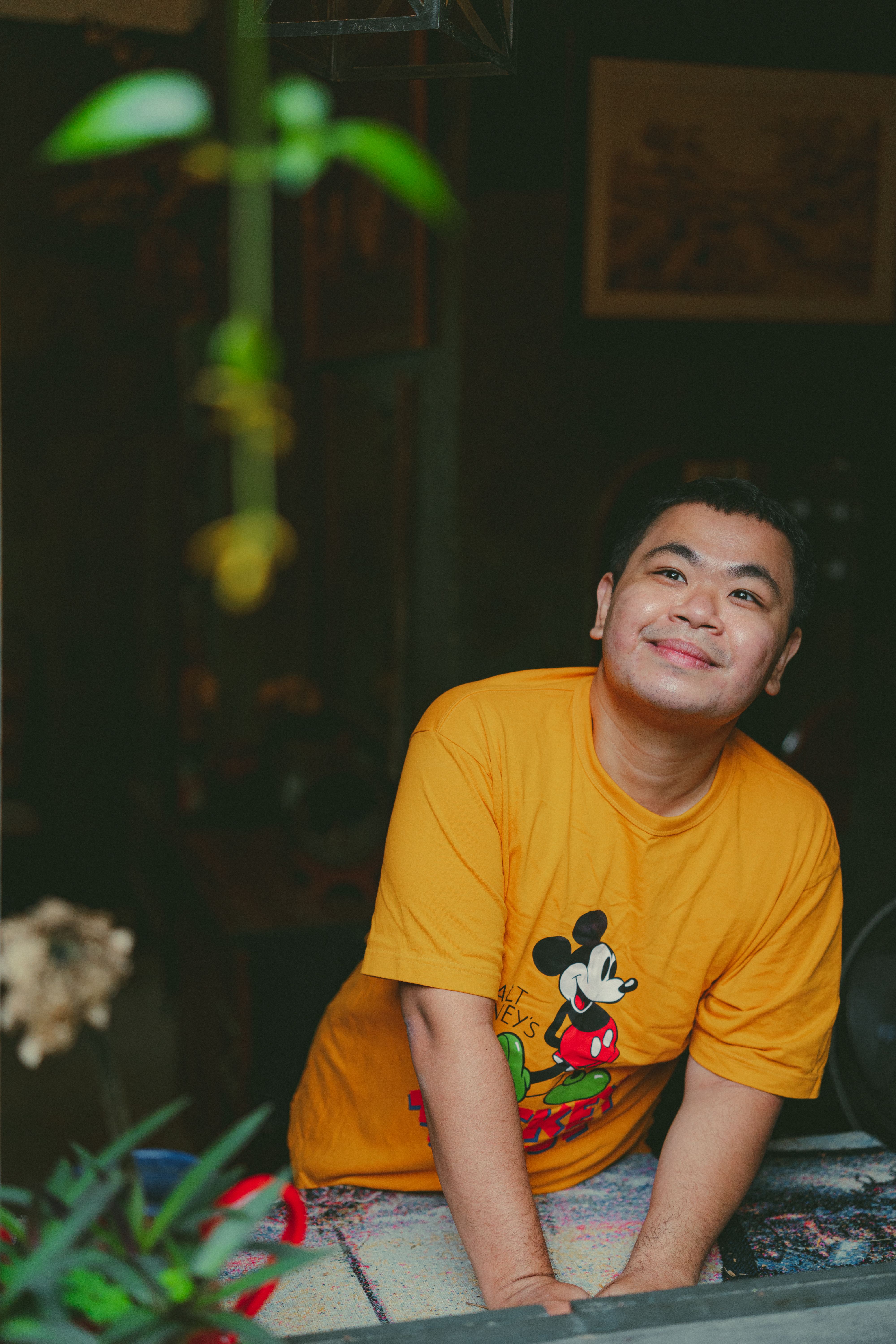 Smiling Man in Yellow Mickey Mouse Shirt · Free Stock Photo