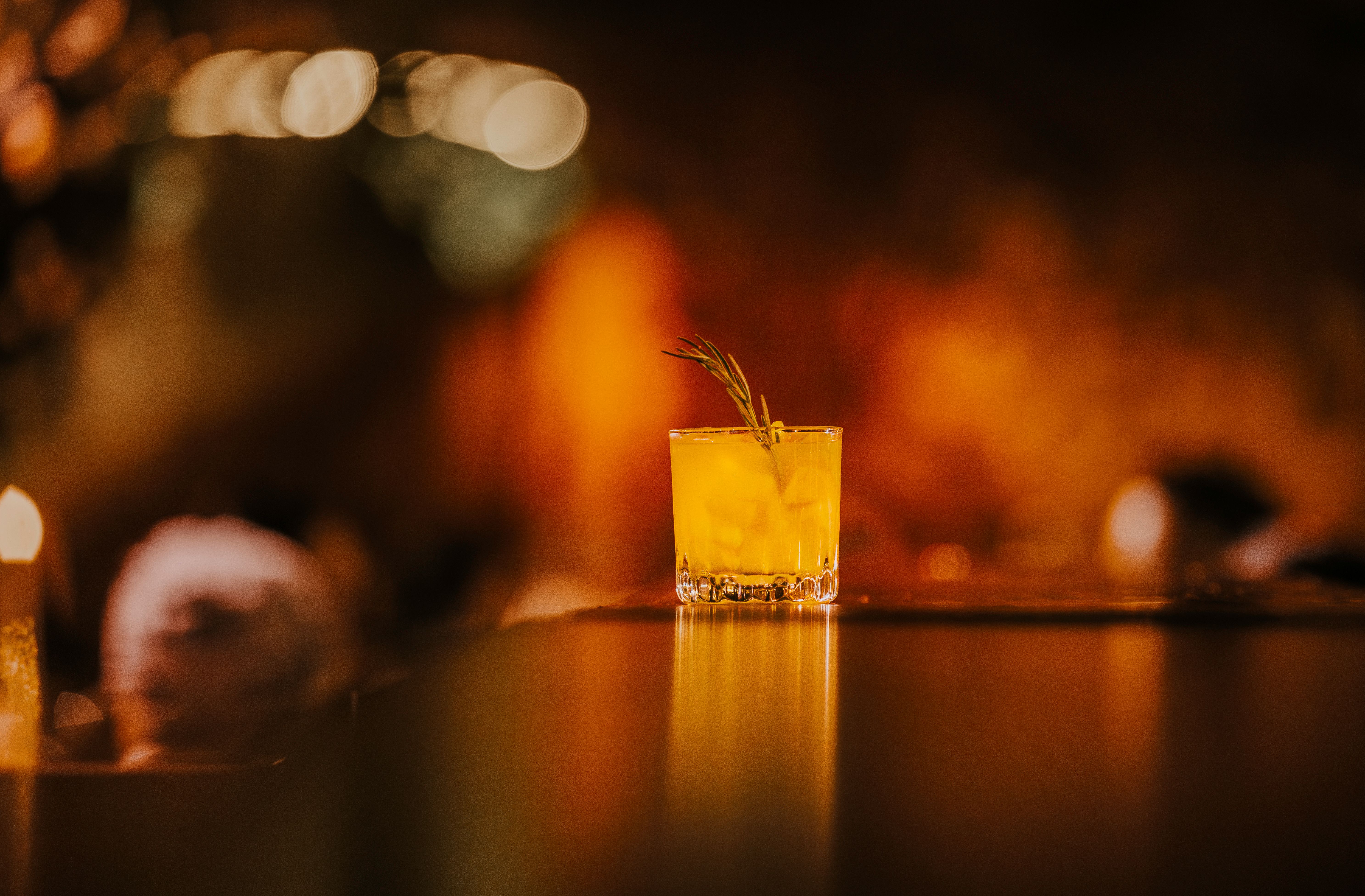 Vibrant Cocktail with Rosemary Garnish on Bar · Free Stock Photo
