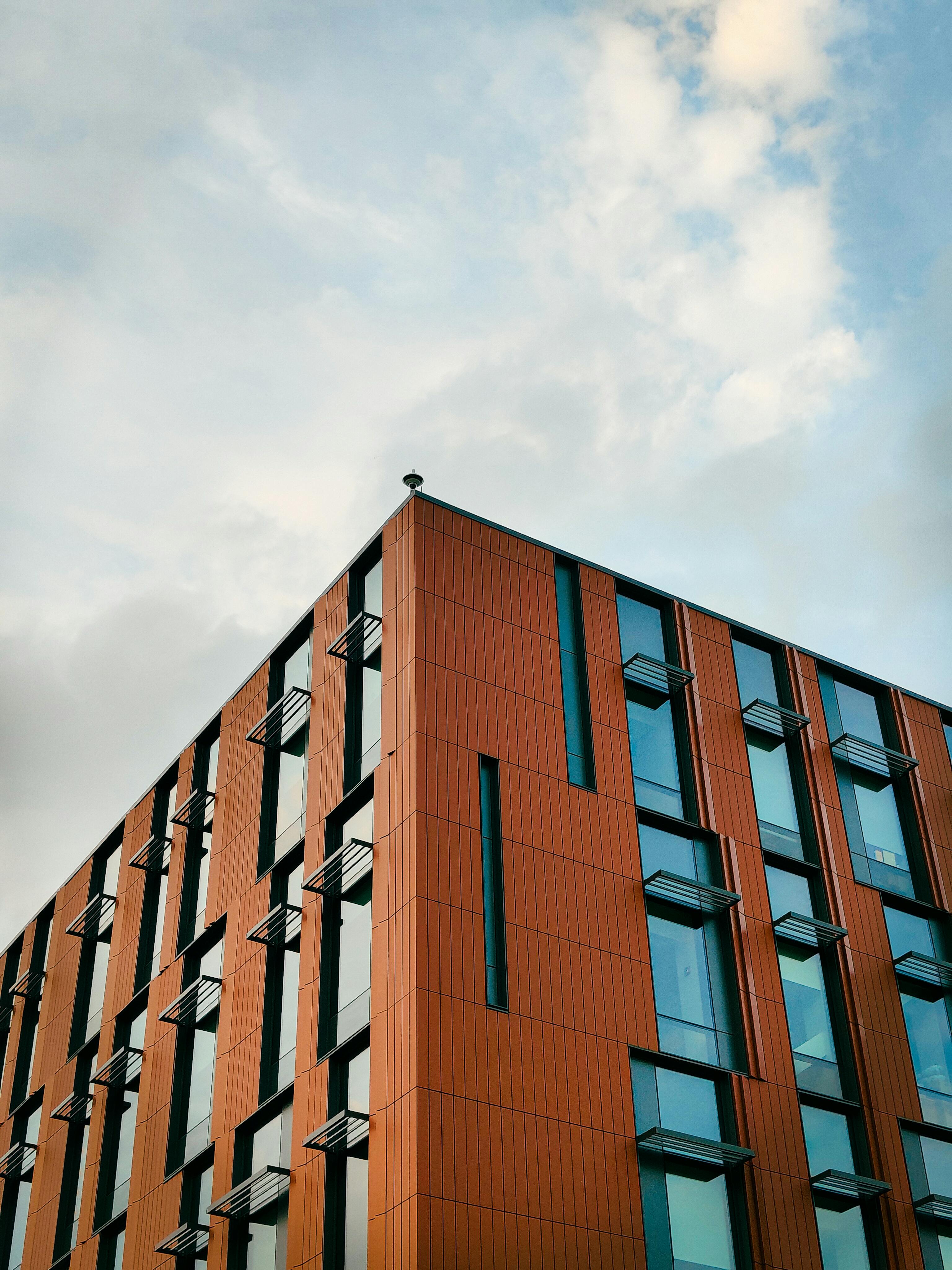 Modern Architectural Building Against Cloudy Sky · Free Stock Photo