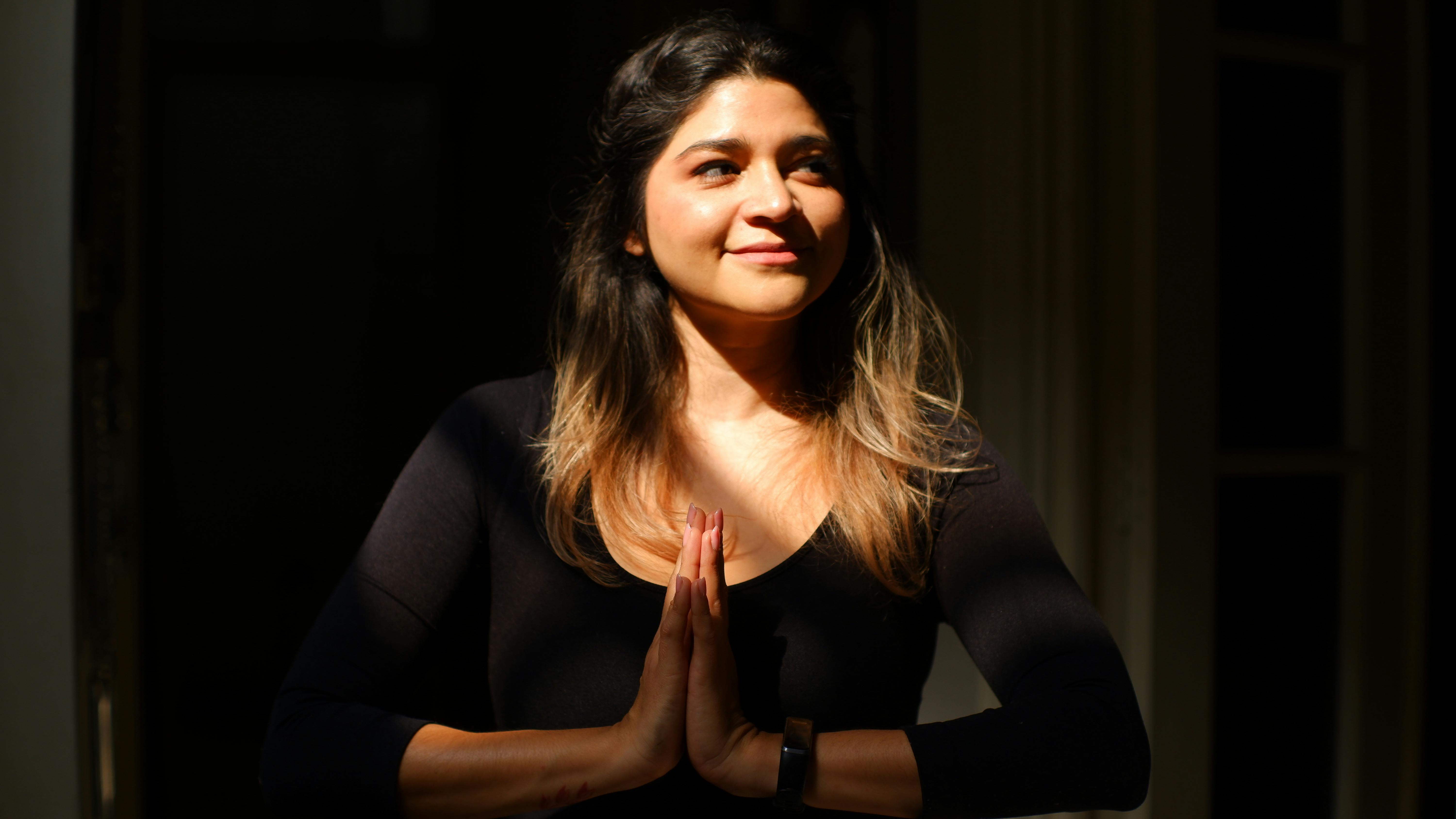 Woman Posing in Sunlight with Namaste Gesture · Free Stock Photo