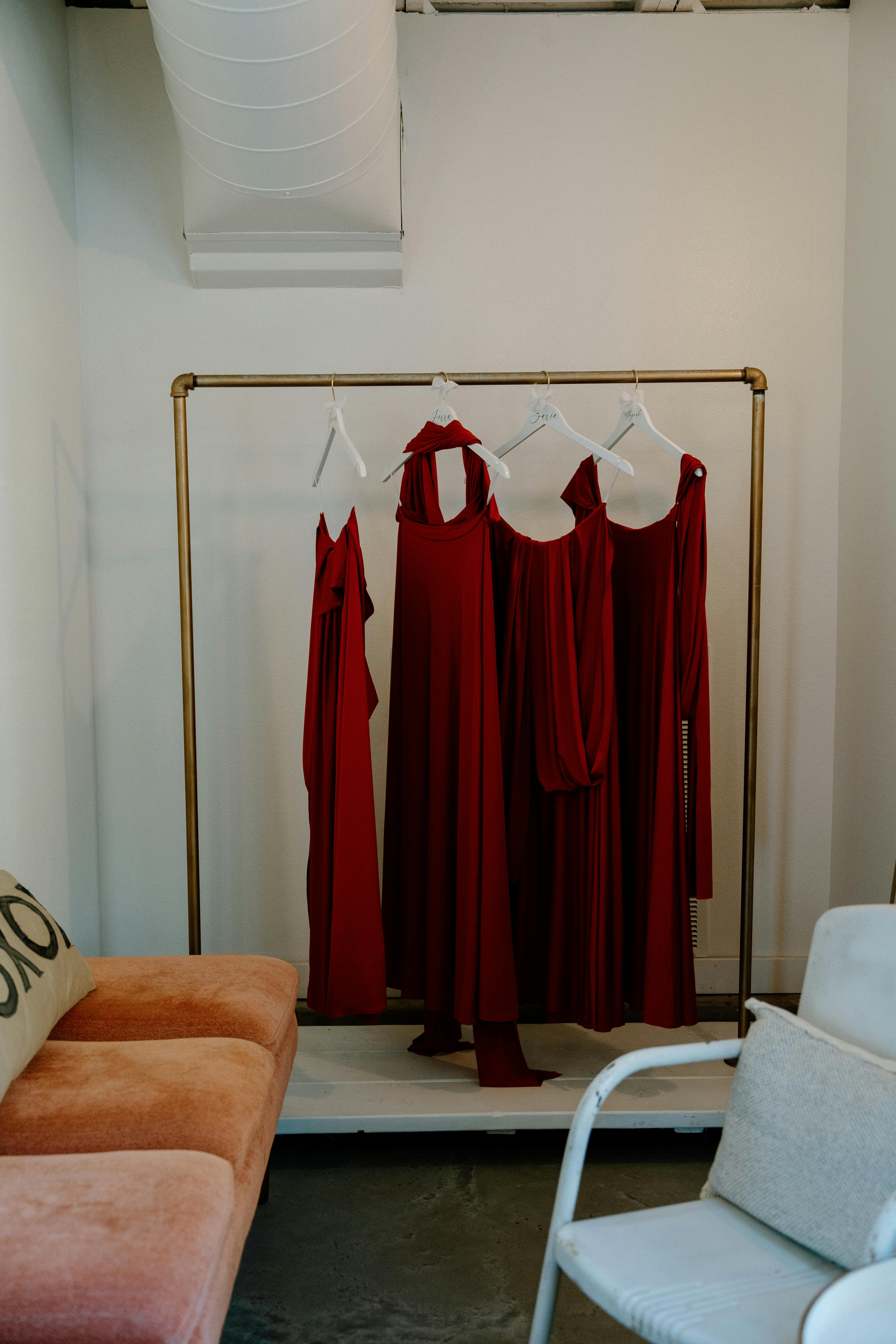 Elegant Red Dresses Hanging on Rack in Modern Boutique · Free Stock Photo