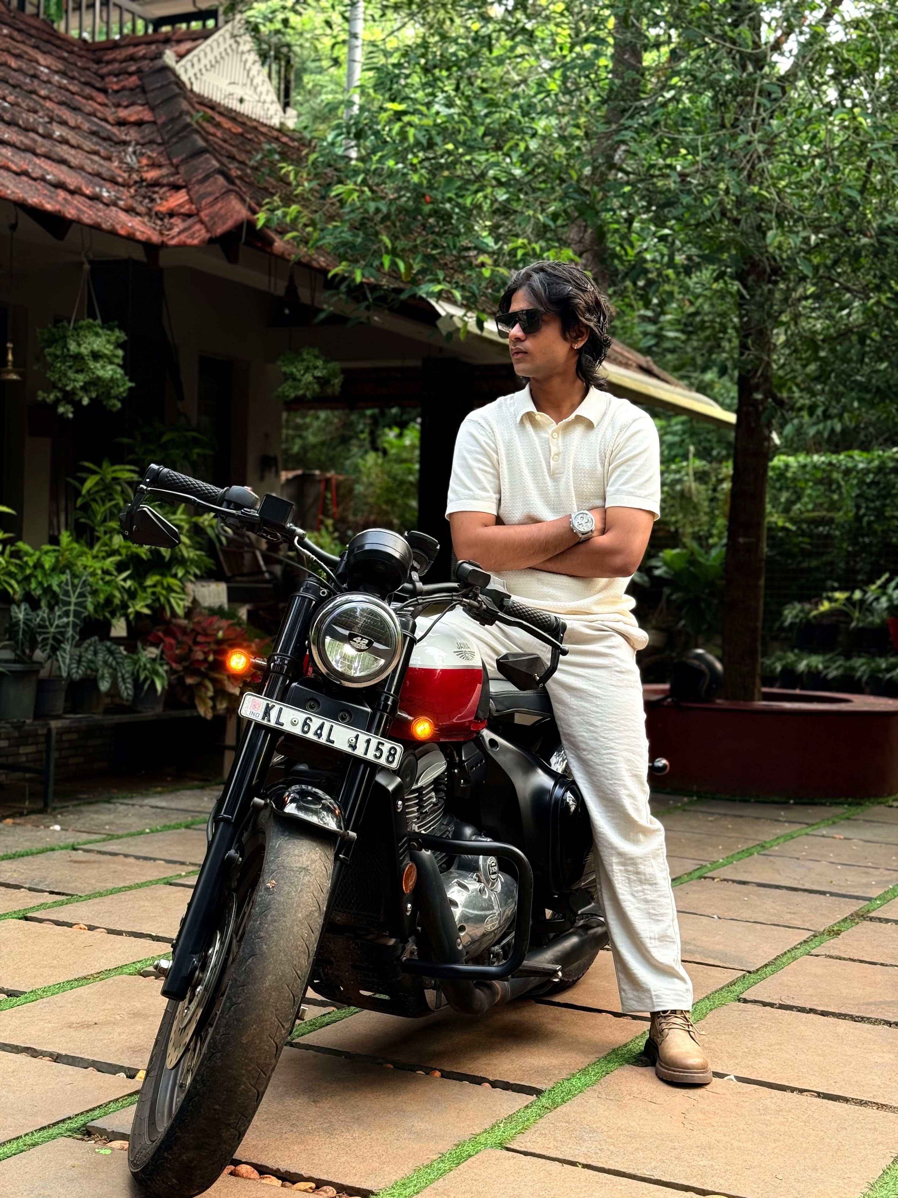 Man Posing with Motorcycle in Indian Garden Setting · Free Stock Photo