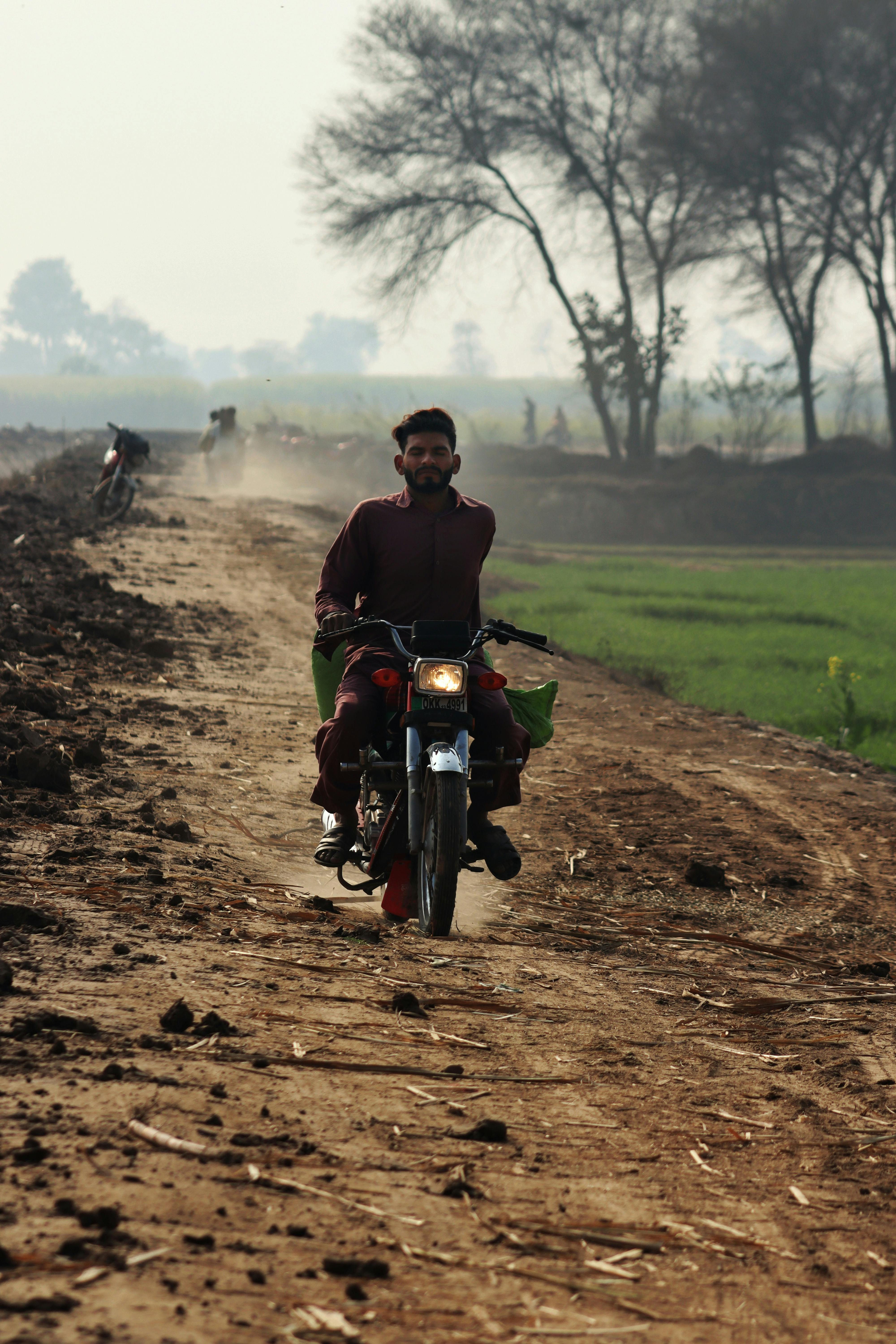 Rural Motorbike Ride on a Dusty Farm Path · Free Stock Photo
