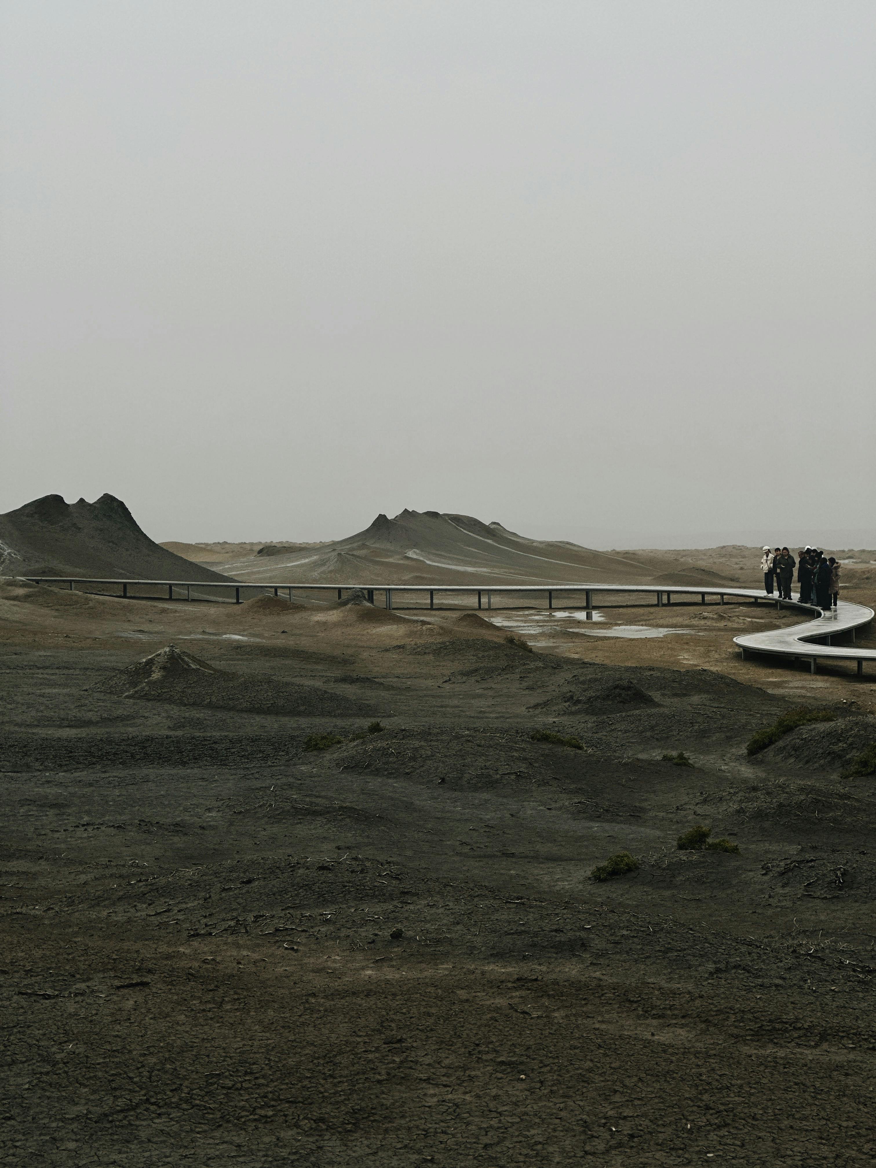 Desolate Landscape with Mud Volcanoes and Pathway · Free Stock Photo
