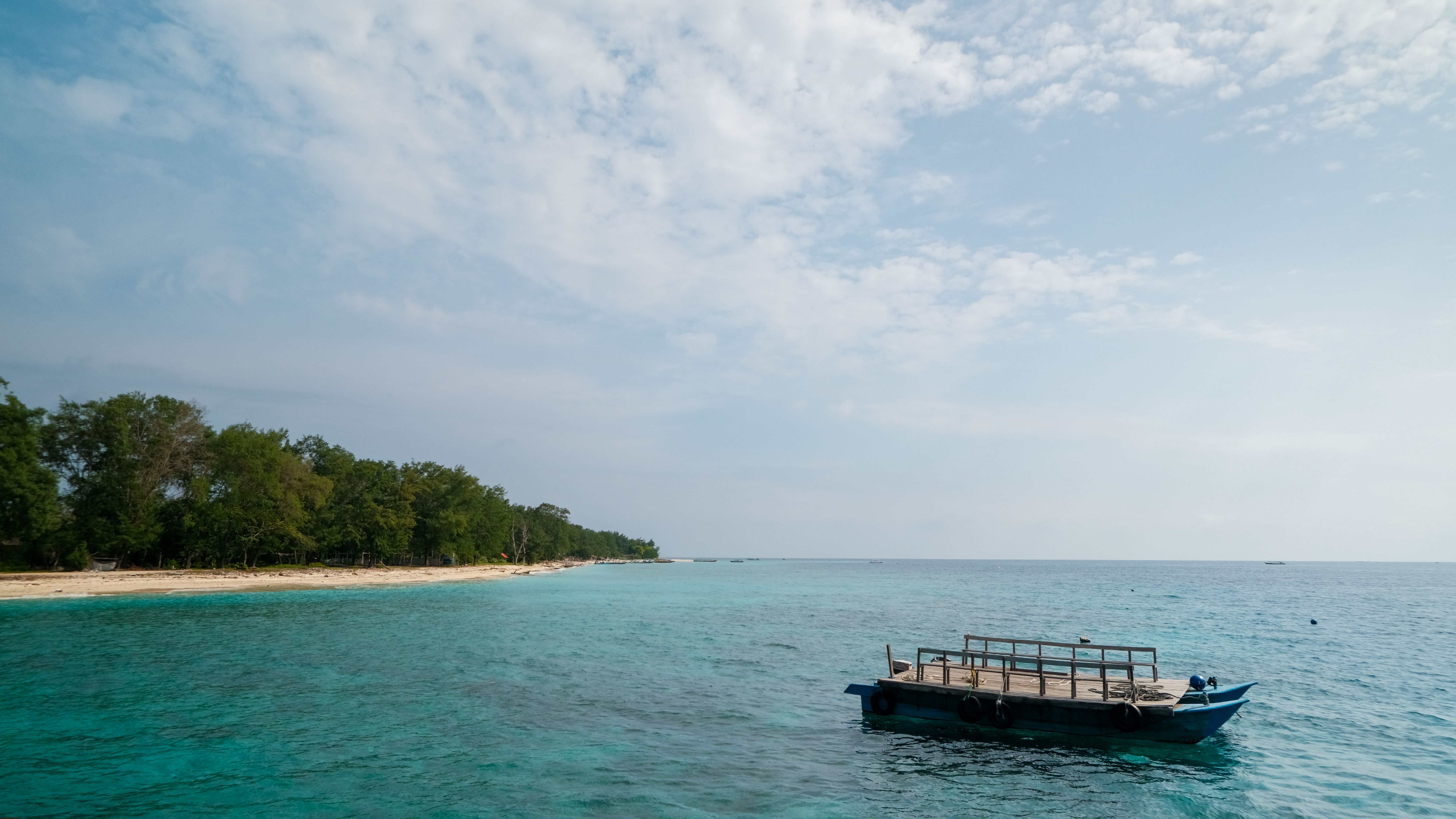 Pemandangan Laut Yang Tenang Dengan Perahu Kayu Dan Pantai Tropis ...