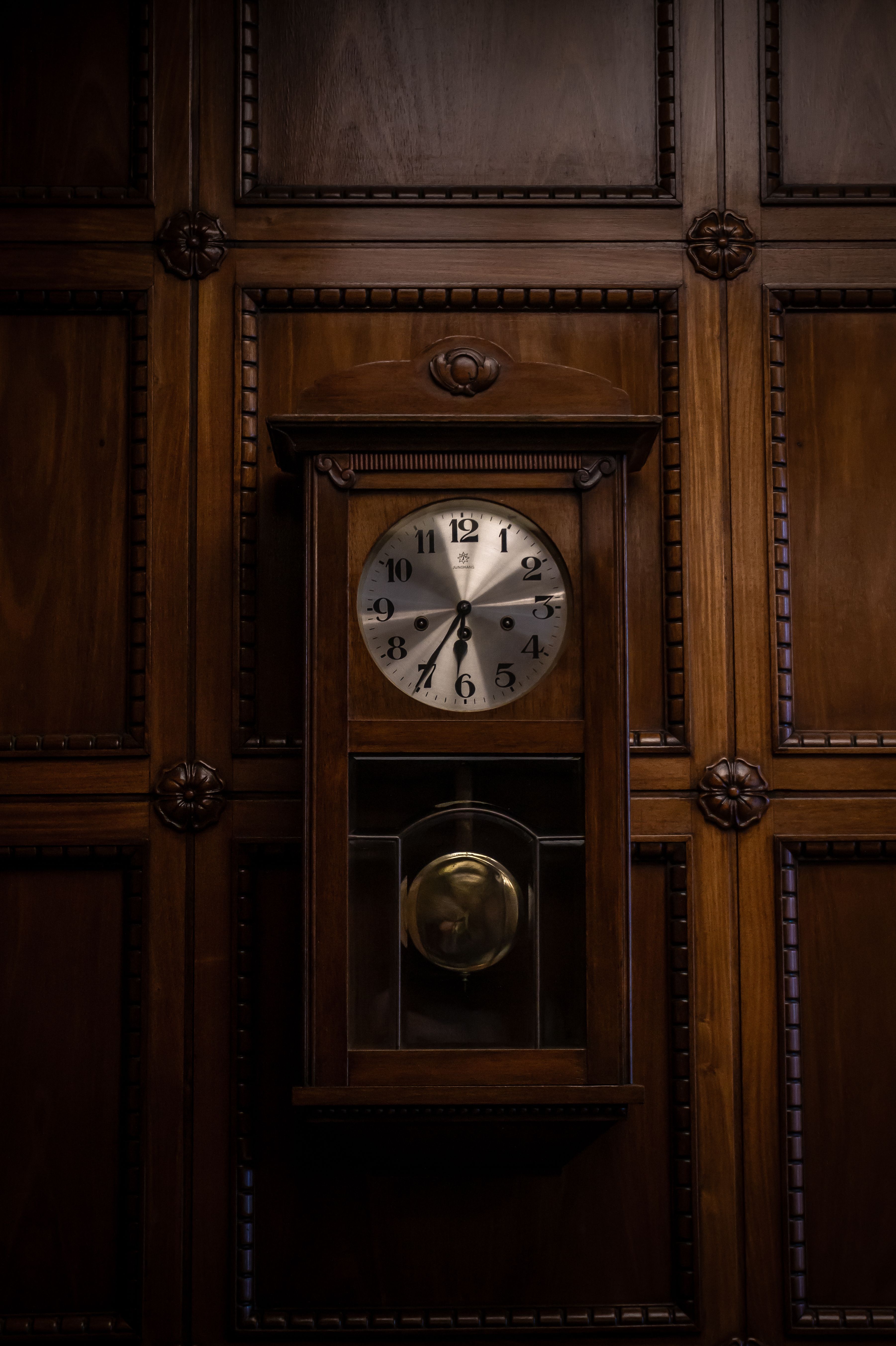 Elegant Vintage Wall Clock Against Wooden Panel · Free Stock Photo