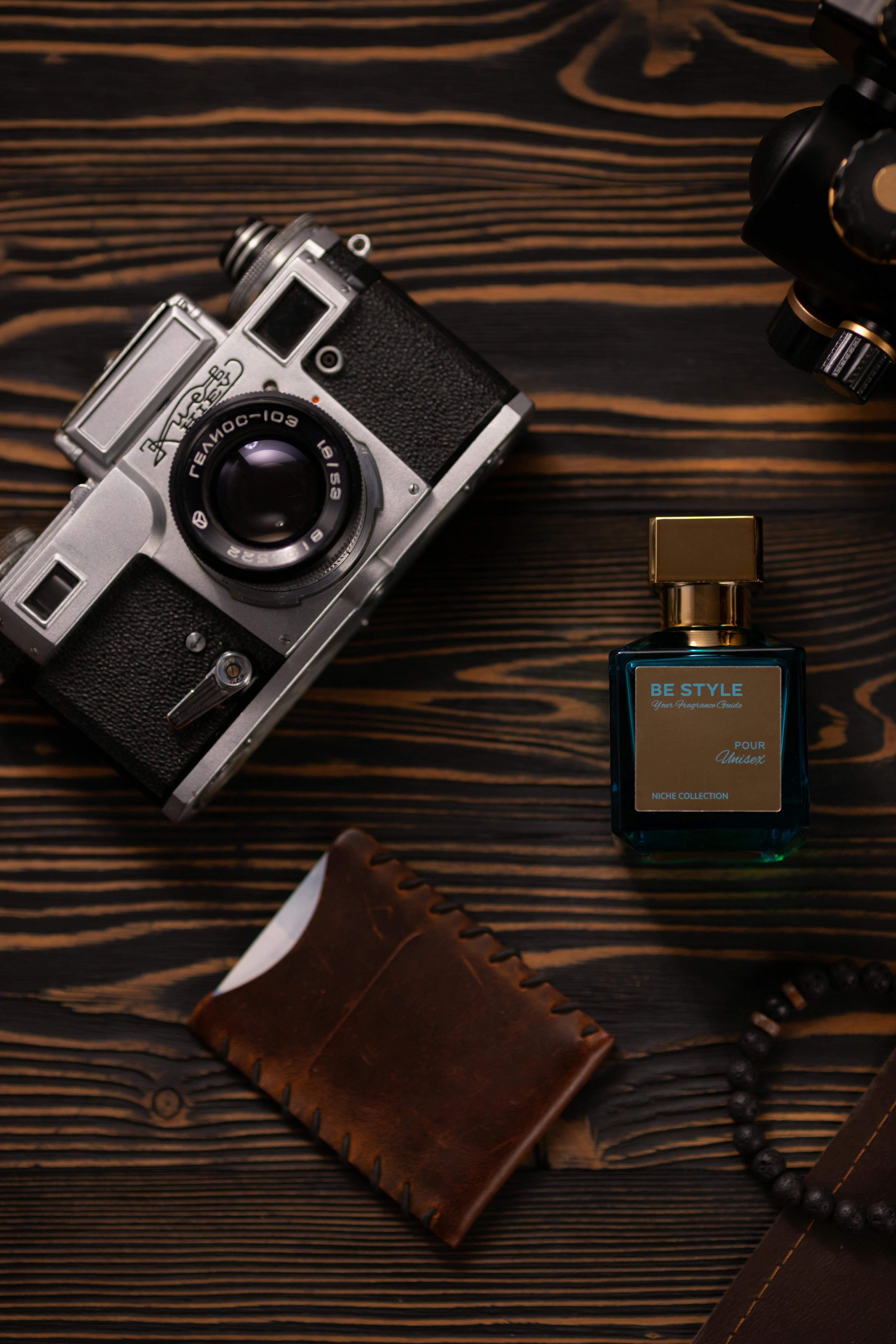 Vintage Camera and Perfume Bottle on Wooden Table · Free Stock Photo