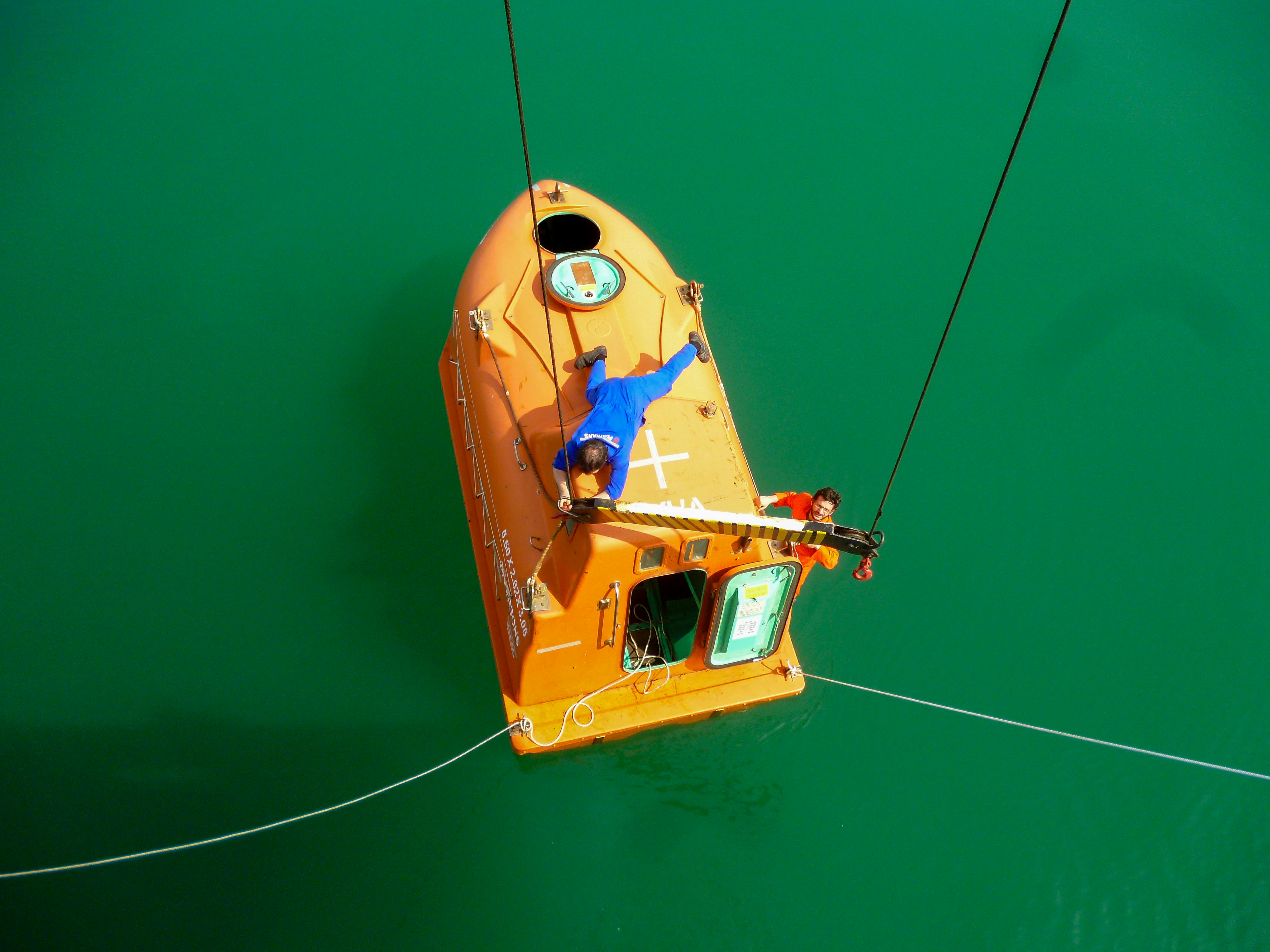 Orange Rescue Capsule Over Green Water · Free Stock Photo